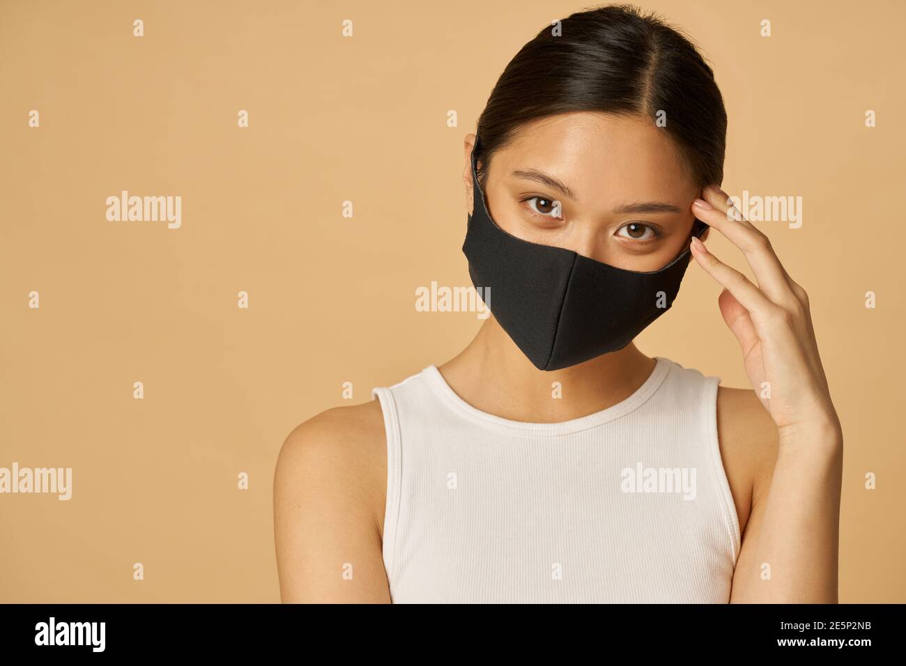 Confident young woman wearing black facial mask looking at camera ...