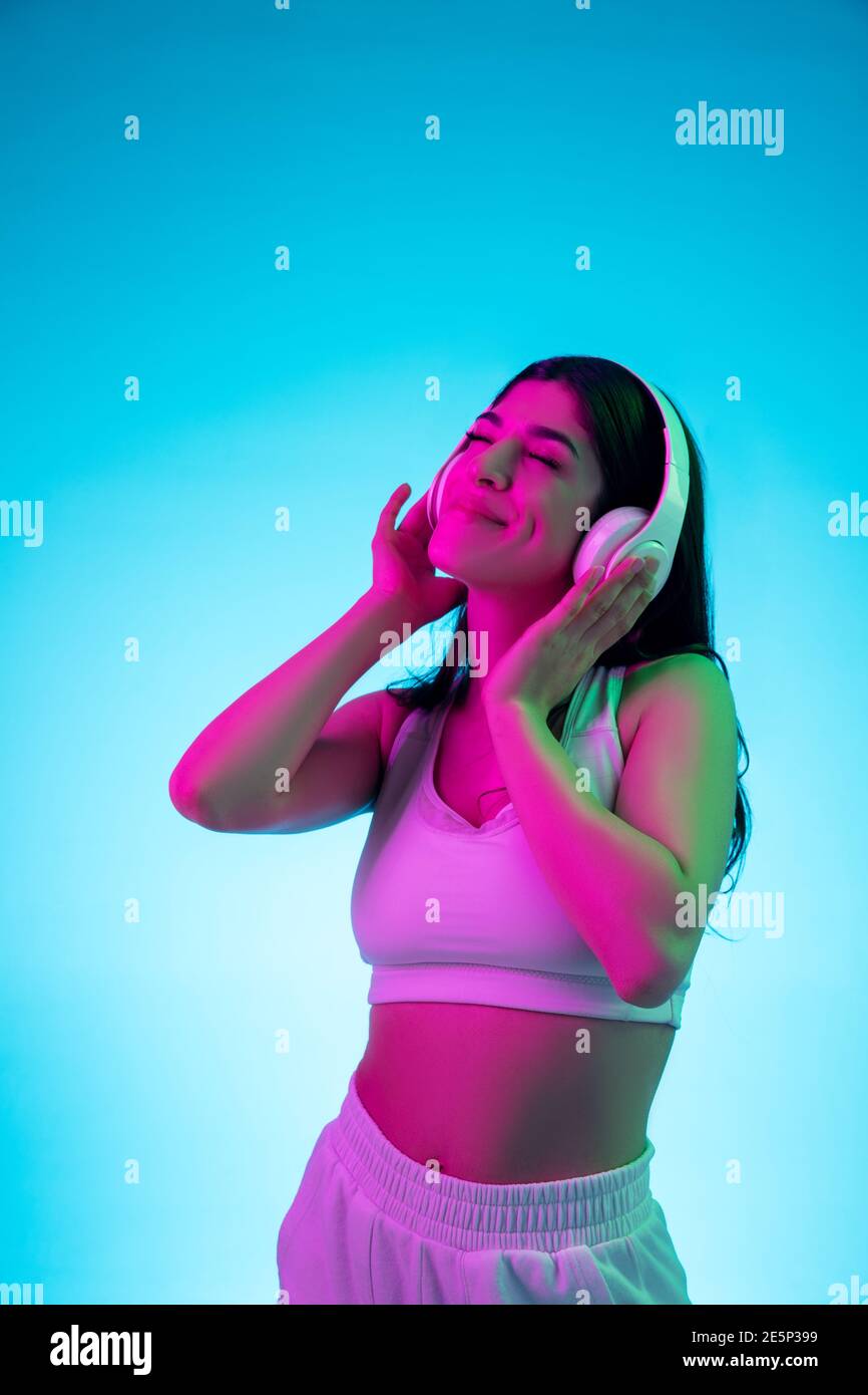 Overjoy. Brunette woman's portrait on blue studio background in mixed ...