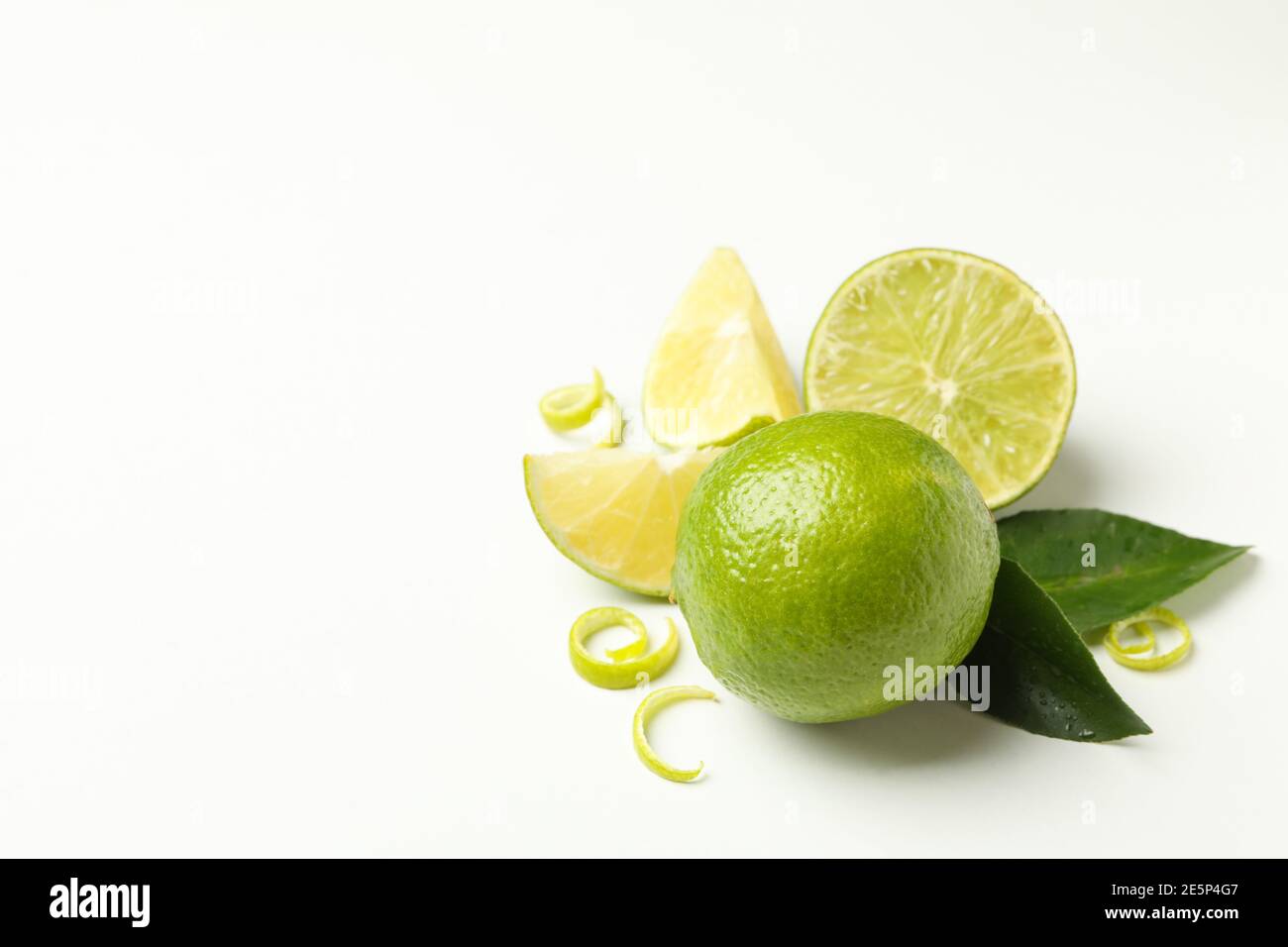 Ripe lime, leaves and peel on white background Stock Photo - Alamy