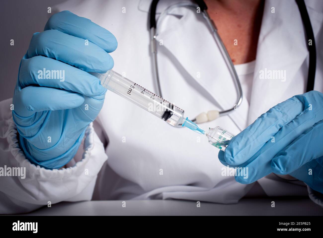 Medical hands holds syringe and vaccine Stock Photo - Alamy