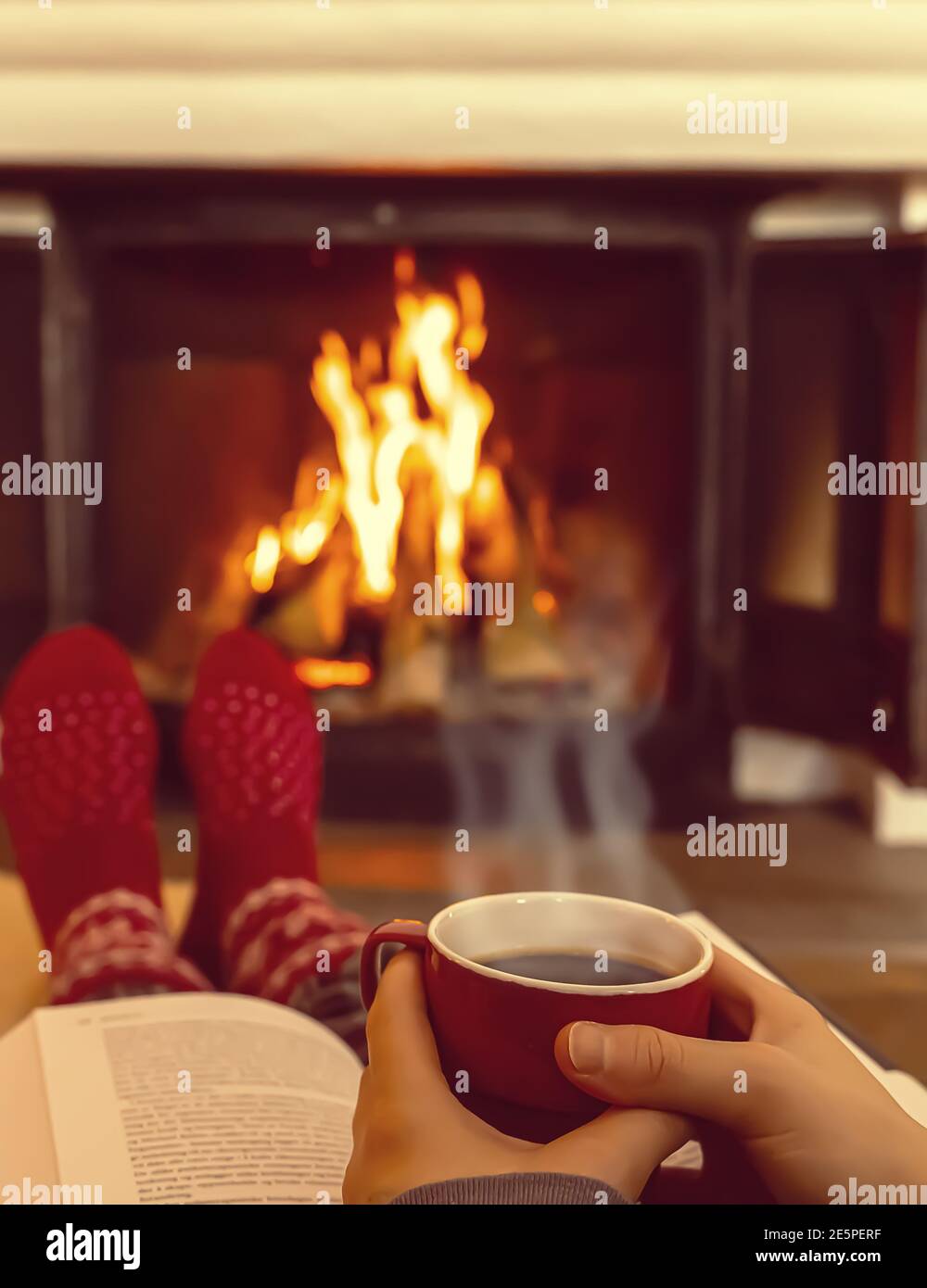 Person resting in front of the fireplace with a steaming hot drink ...