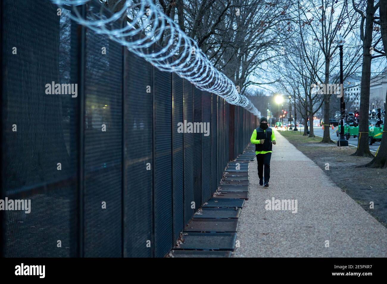 Washington, United States. 28th Jan, 2021. A man jogs past a razor wire ...