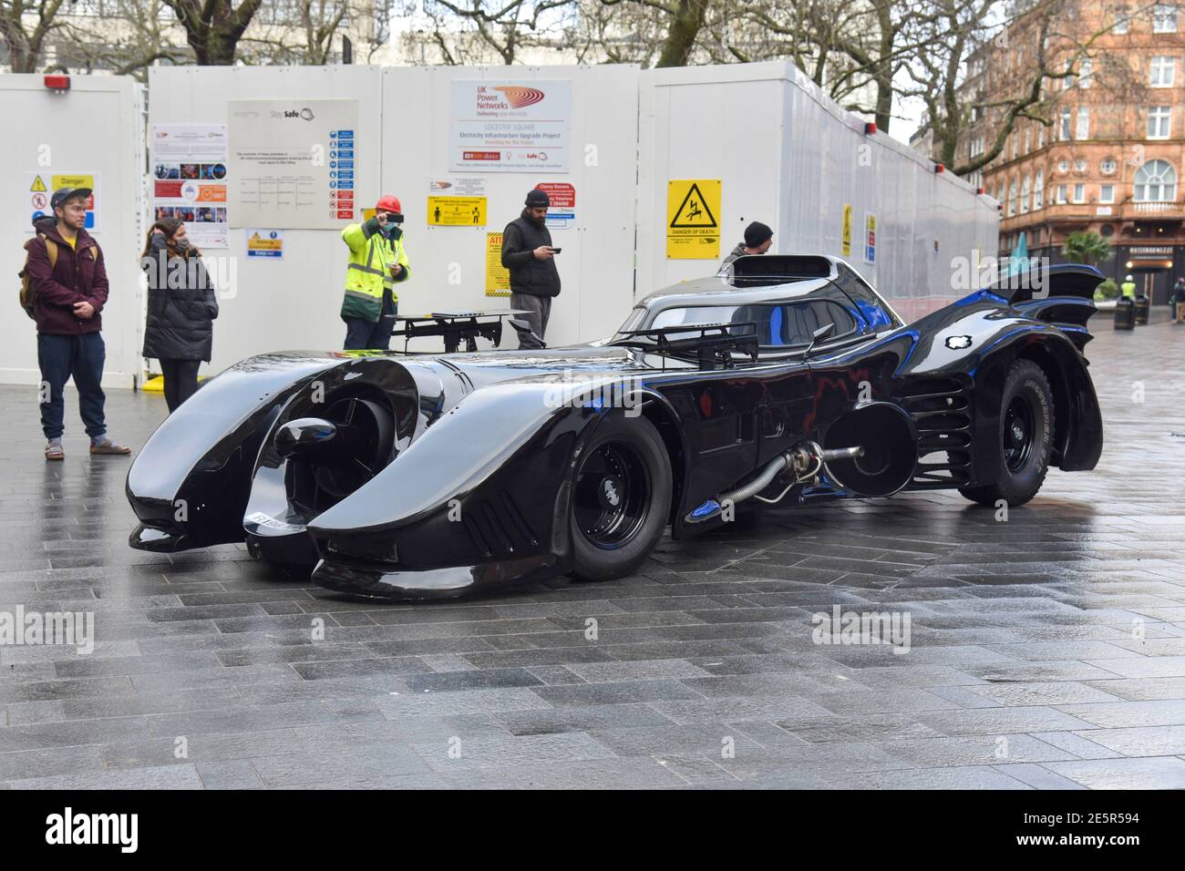London, UK. 28th Jan, 2021. People look on at the Batmobile outside the ...
