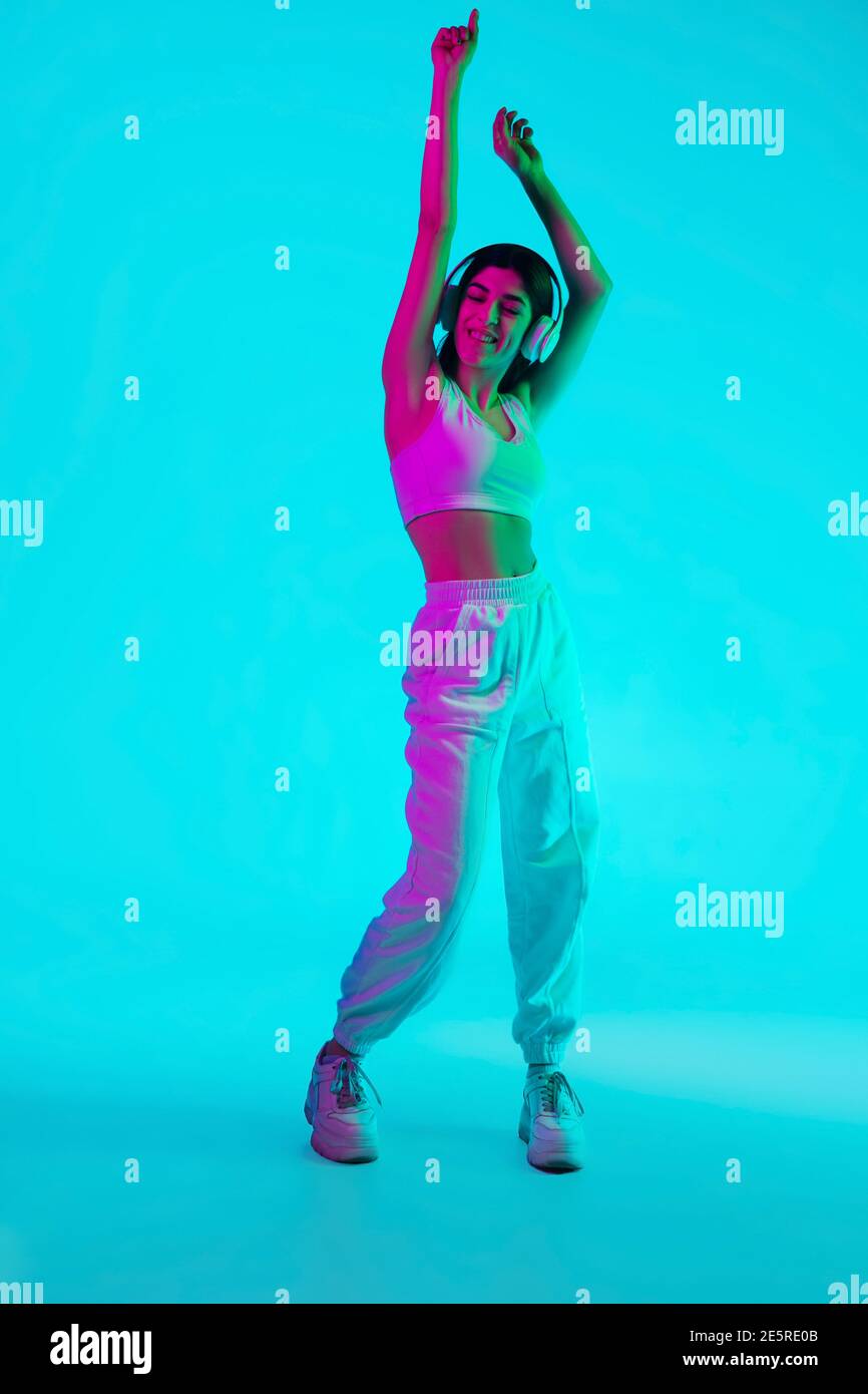 Overjoy. Brunette woman's portrait on blue studio background in mixed ...