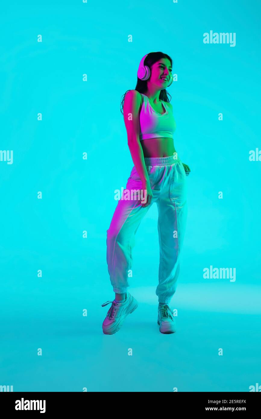 Overjoy. Brunette woman's portrait on blue studio background in mixed ...