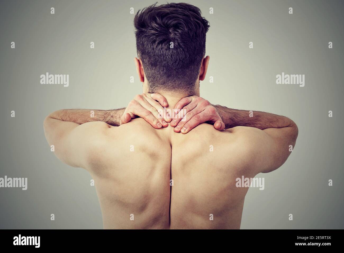 Back view of a young man with neck pain Stock Photo - Alamy
