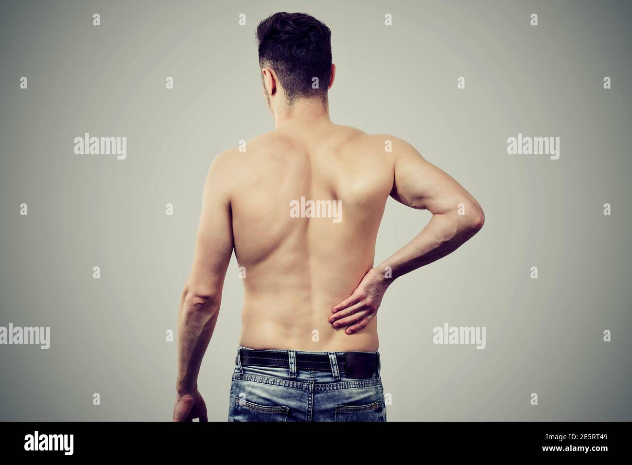 Back view of a young fit man with a lower back pain Stock Photo - Alamy