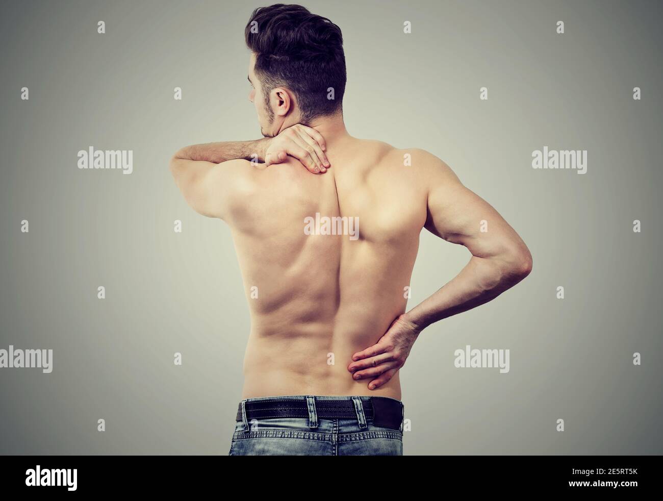 Back view of a young man with neck and lower back pain Stock Photo - Alamy