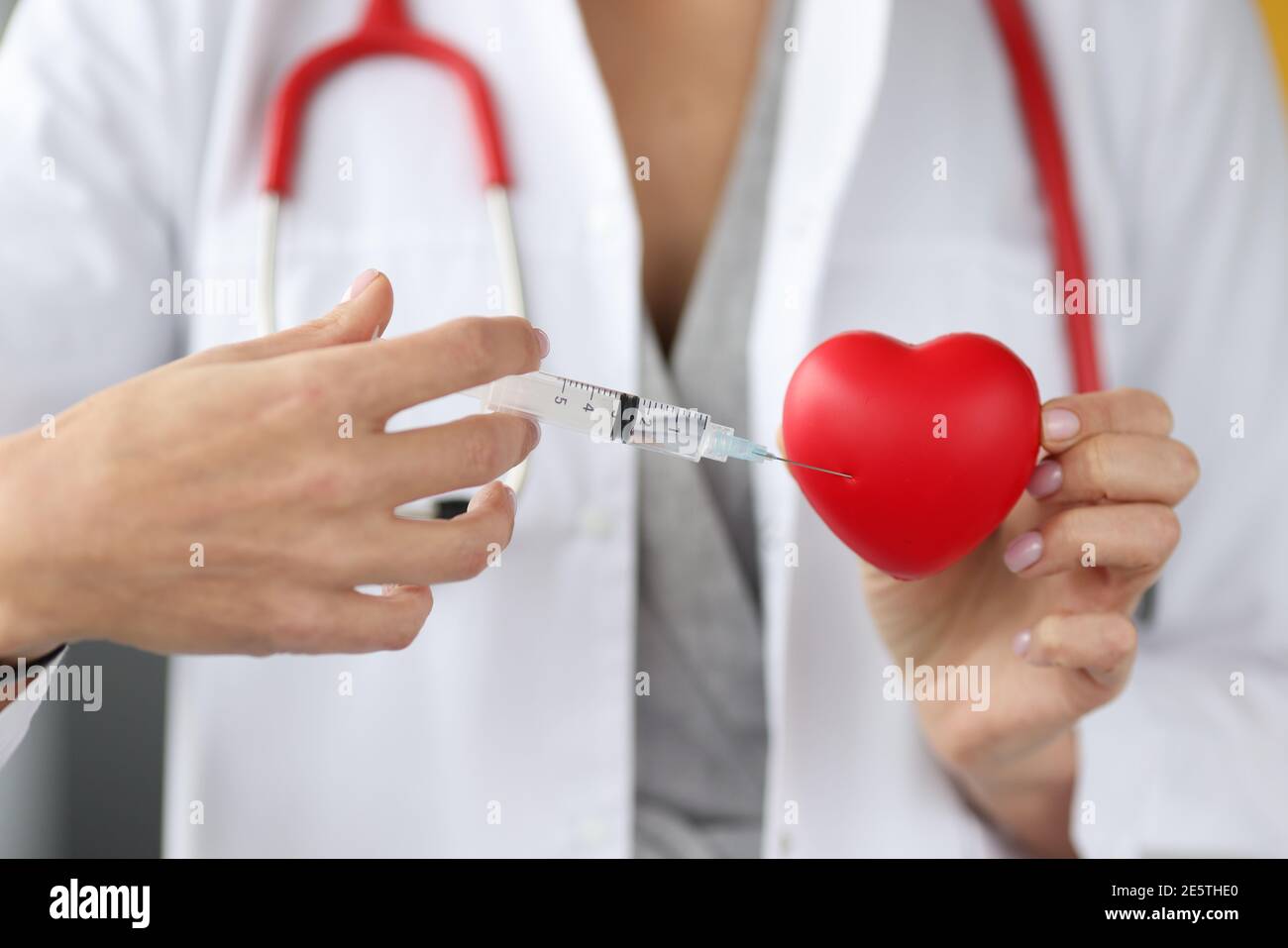 Doctor injecting medicine into red toy heart closeup Stock Photo - Alamy
