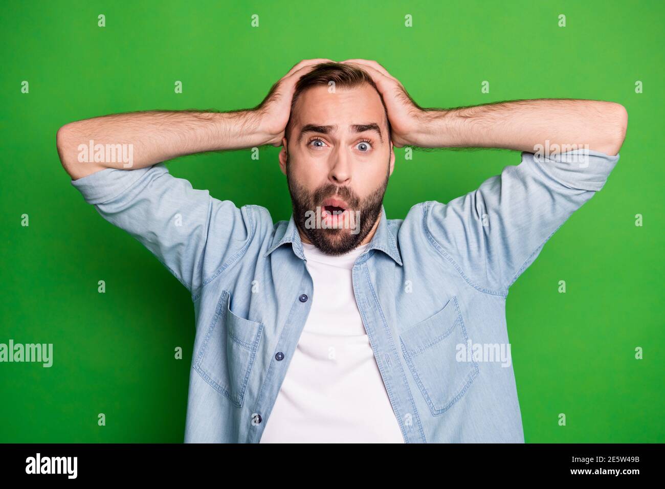Portrait of impressed sad man wear blue shirt arm head open mouth ...