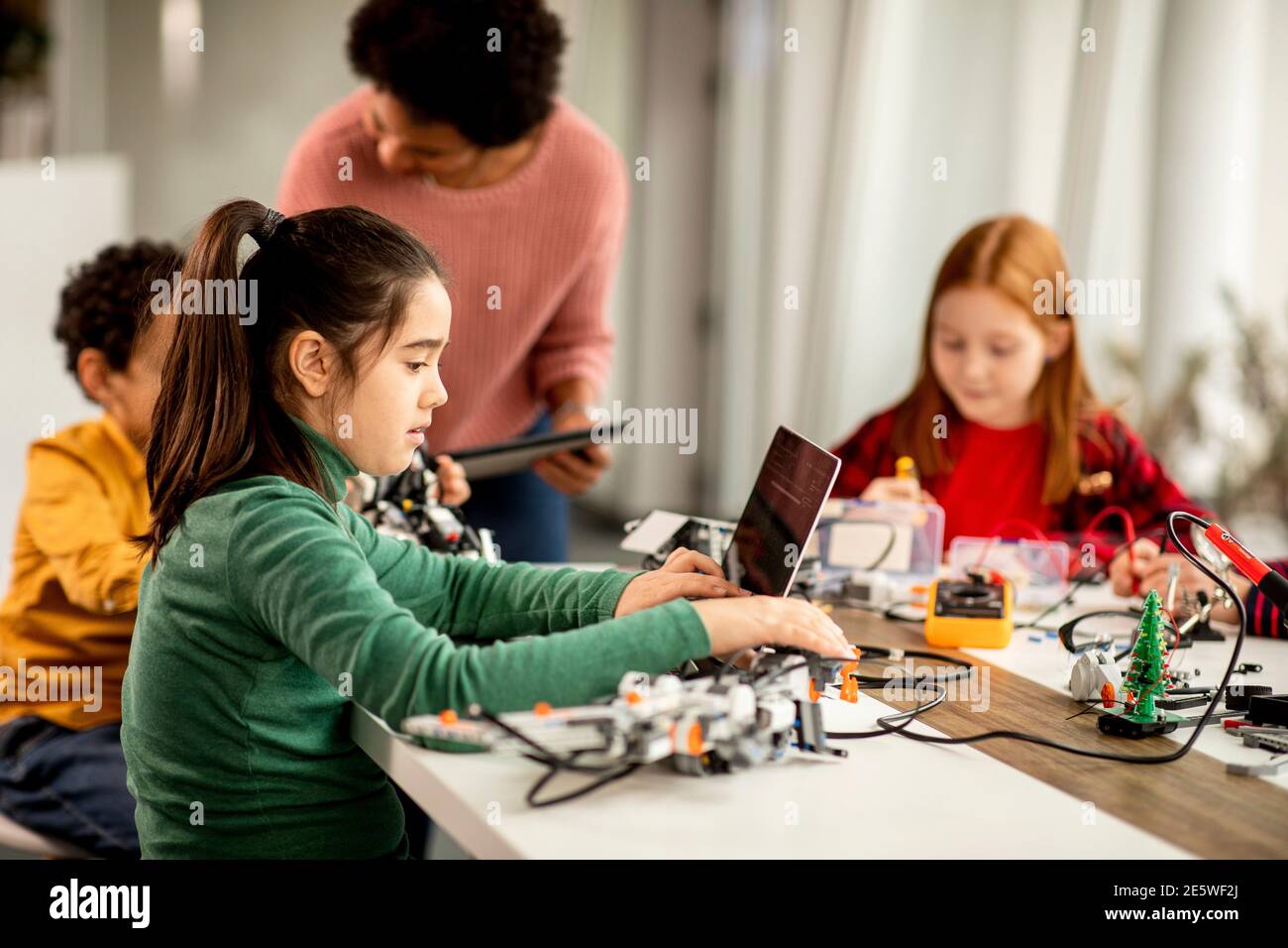 Group of happy kids with their African American female science teacher ...