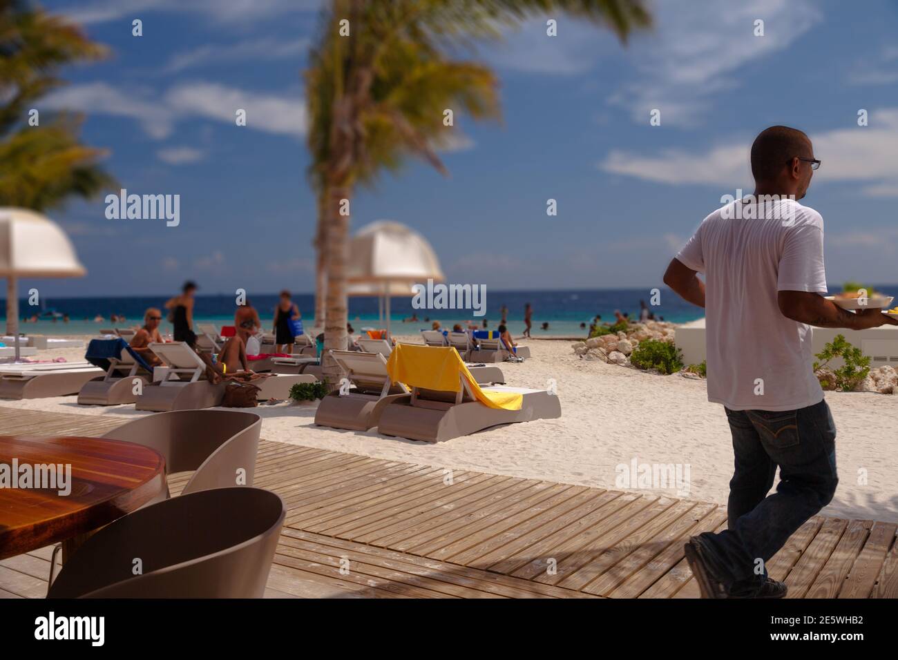 Waiter carrying food at beach Stock Photo - Alamy