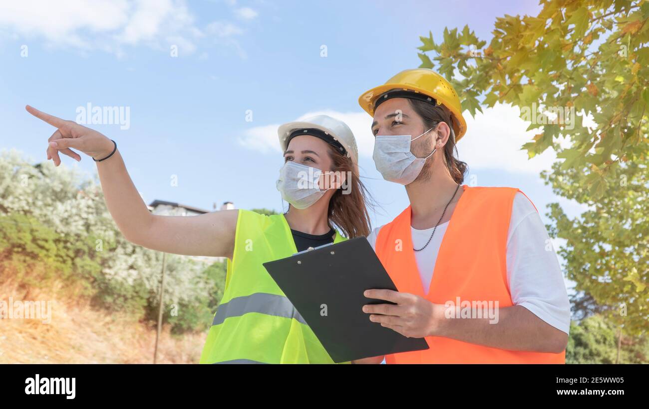 Portrait of worker and engineer wearing face masks checking production ...
