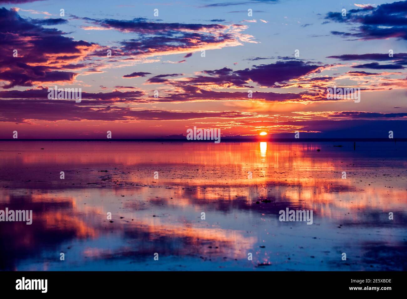 A sunset over a body of water Stock Photo - Alamy