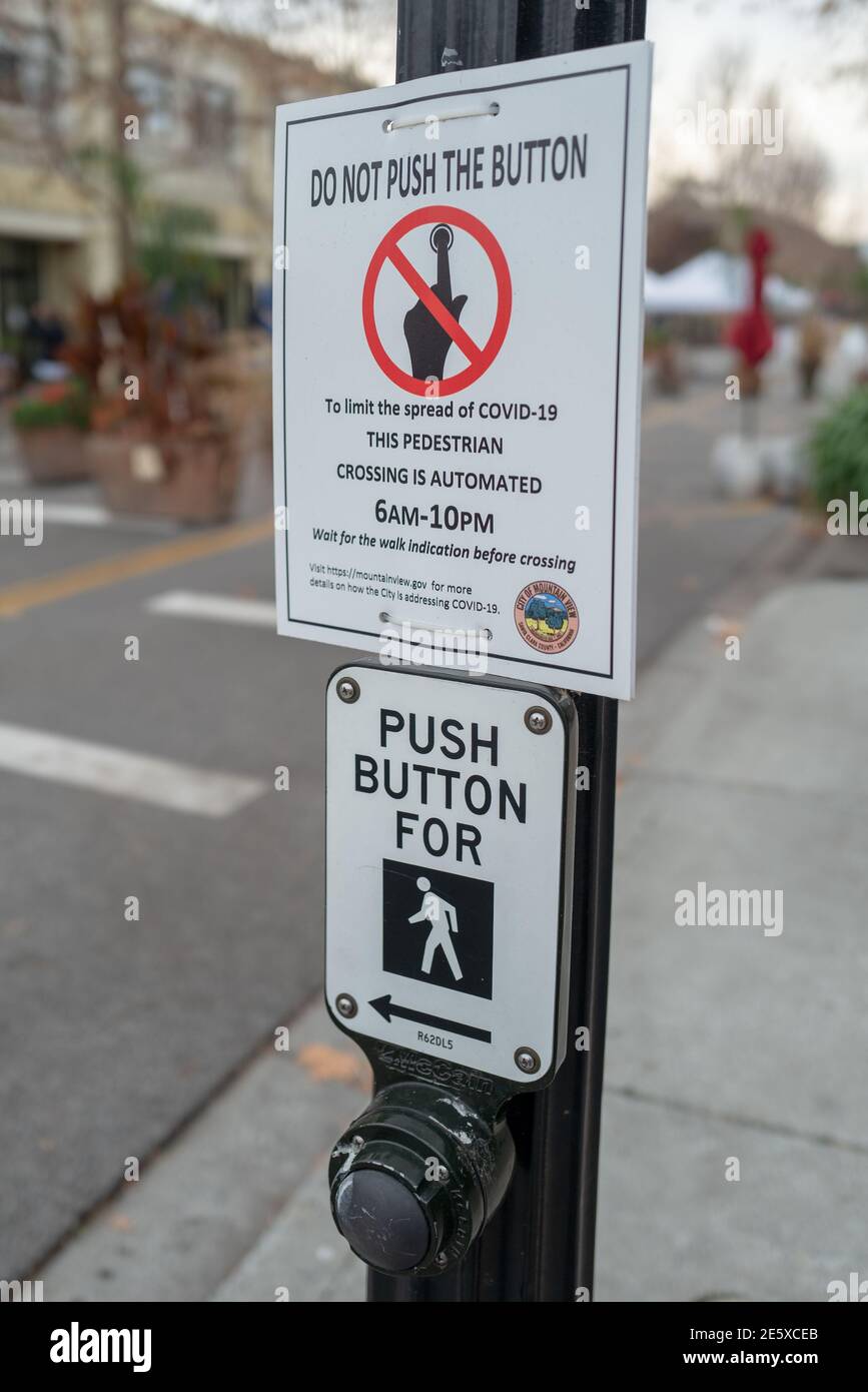 Sign instructing pedestrians not to push a crosswalk button due to ...