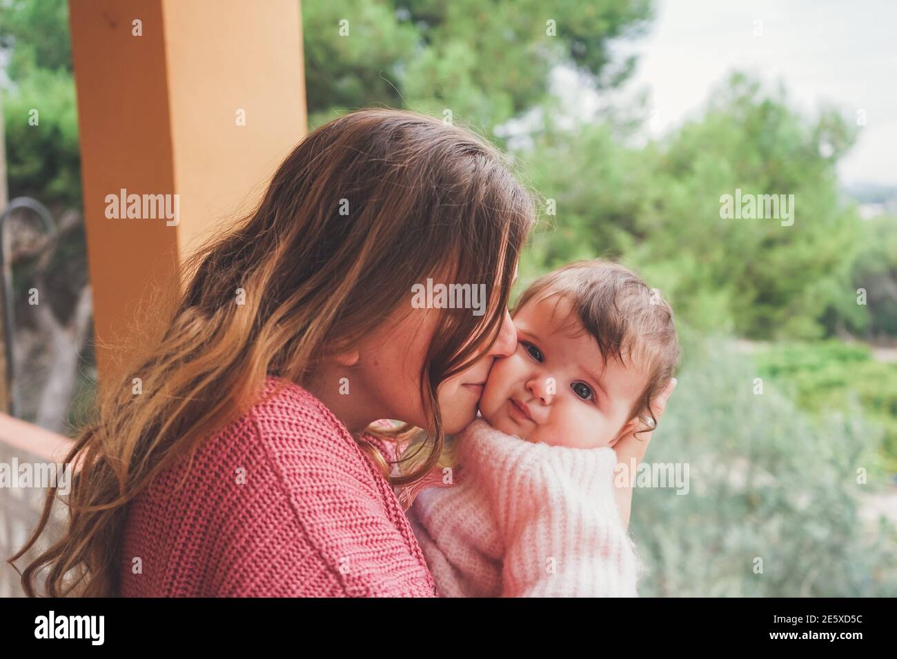 Young mother hugging her baby Stock Photo - Alamy