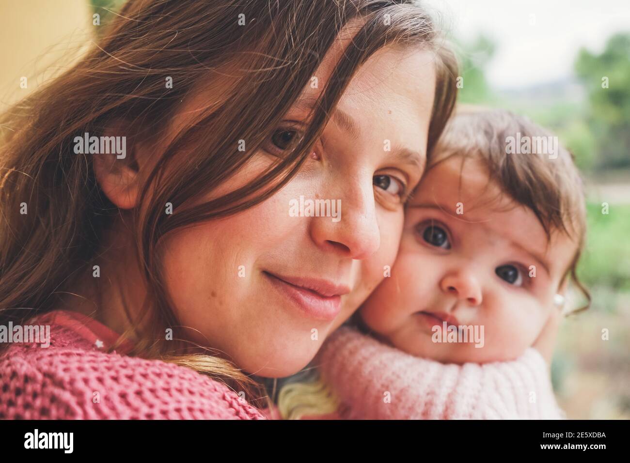 Young mother hugging her baby Stock Photo - Alamy