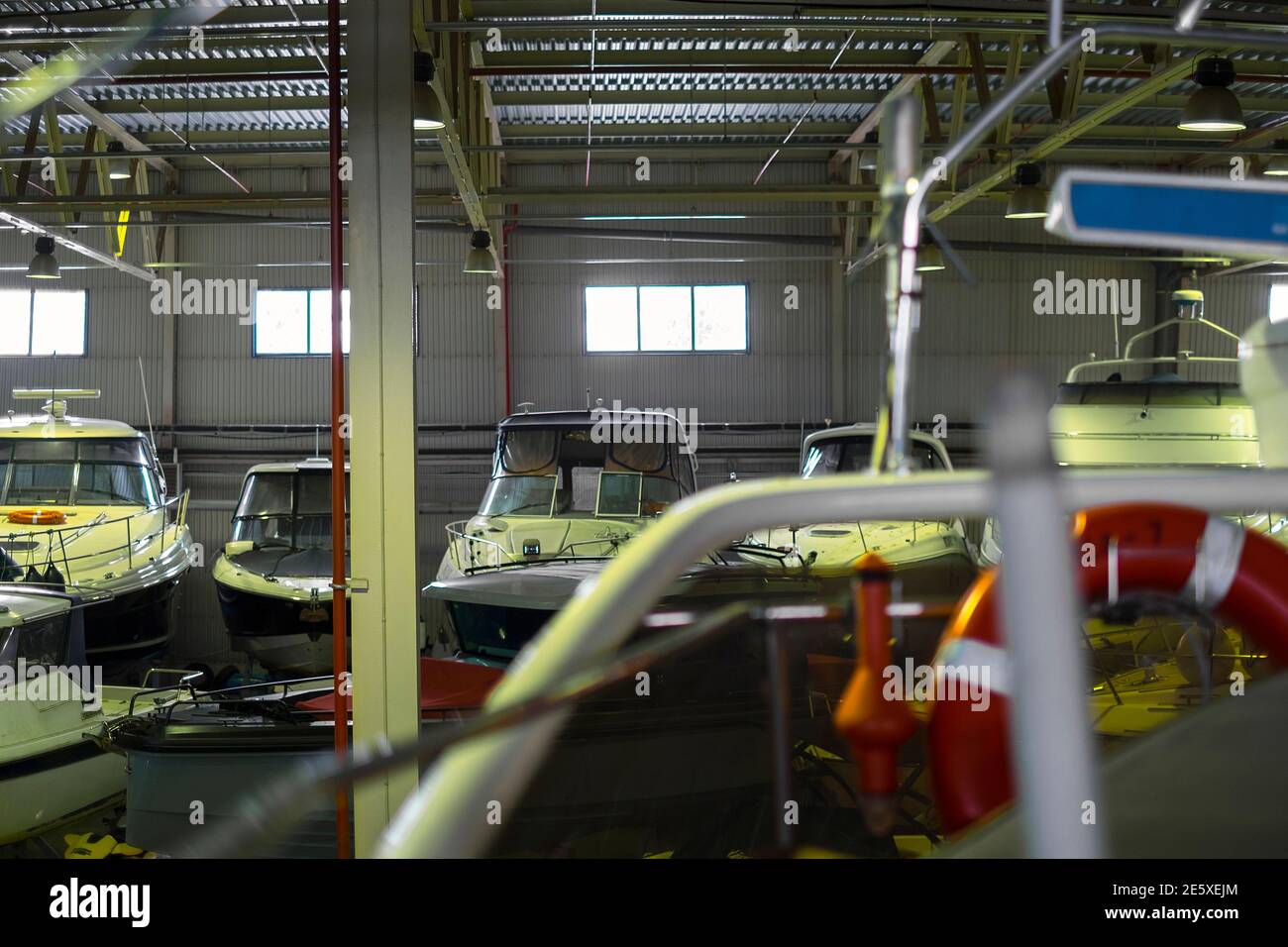 Dry boatyard storage with stack of yachts, indoor shot, focus in the ...