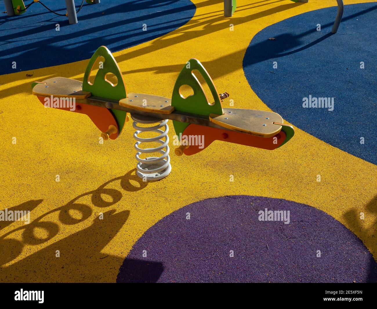 Rocker swing on a playground with a brightly colored rubber floor Stock ...