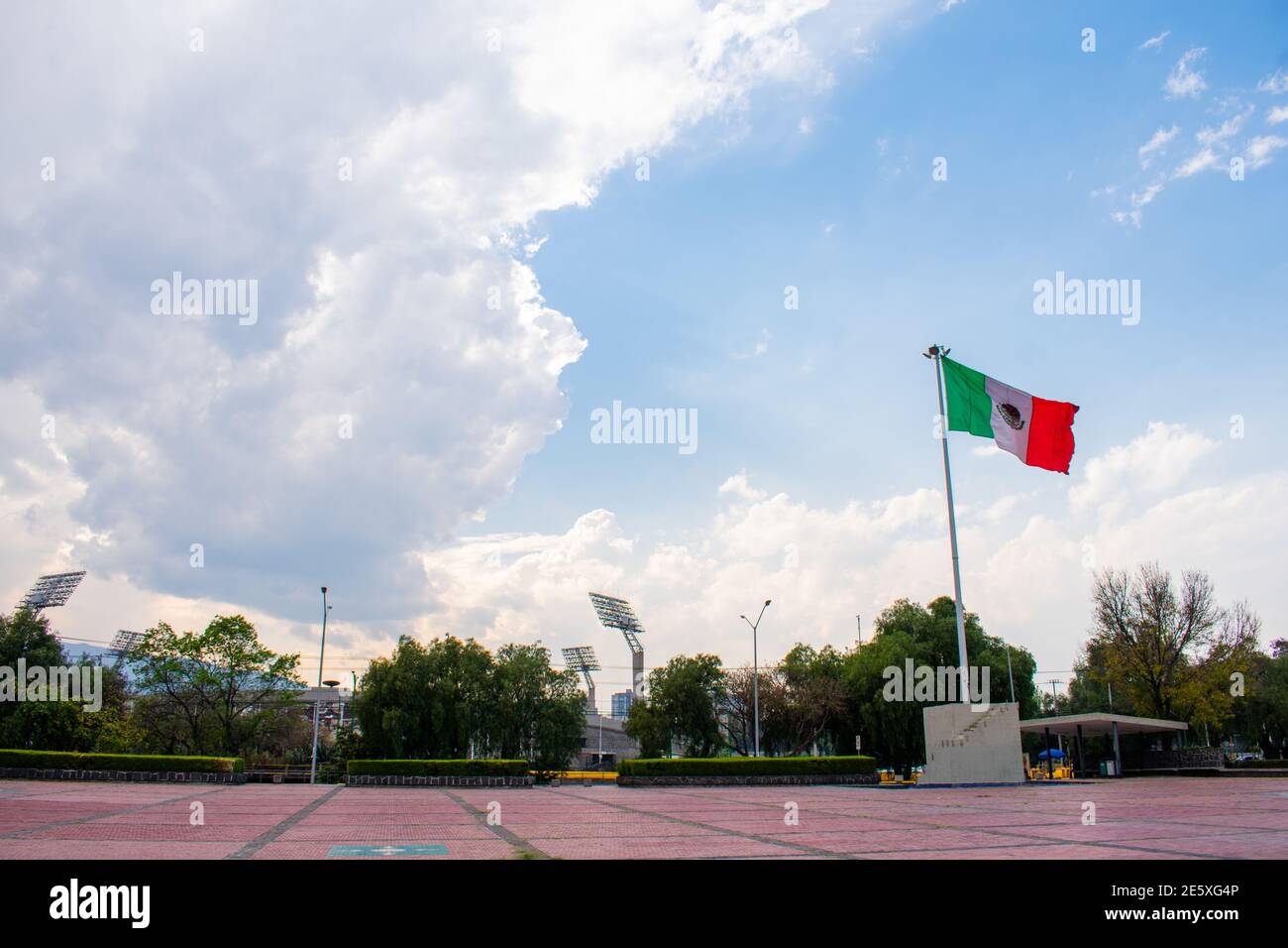 Wavy Mexican flag in public square with a cloudy sky as background ...