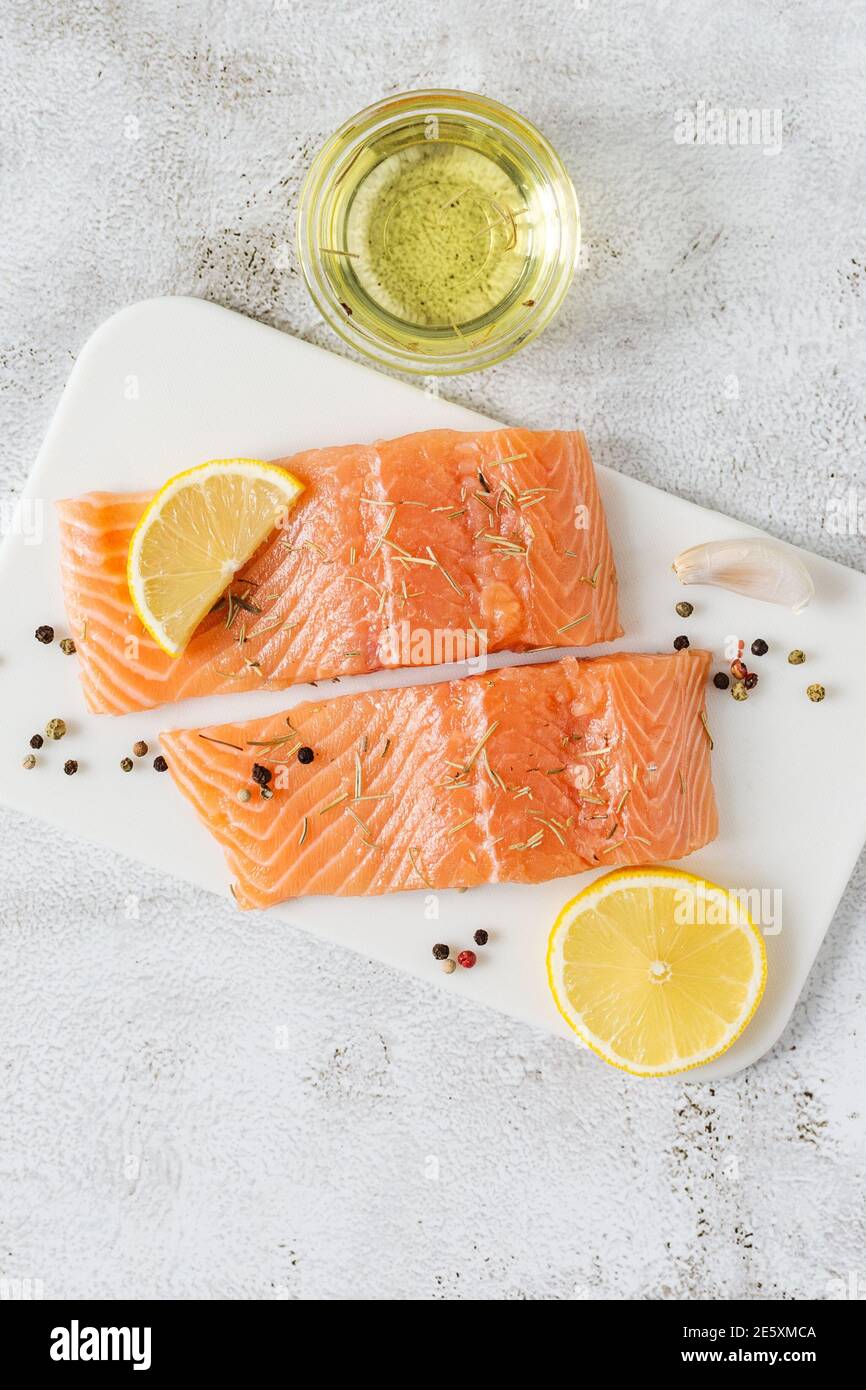 Fresh uncooked salmon fish fillet with cooking spices, oil and lemon on ...