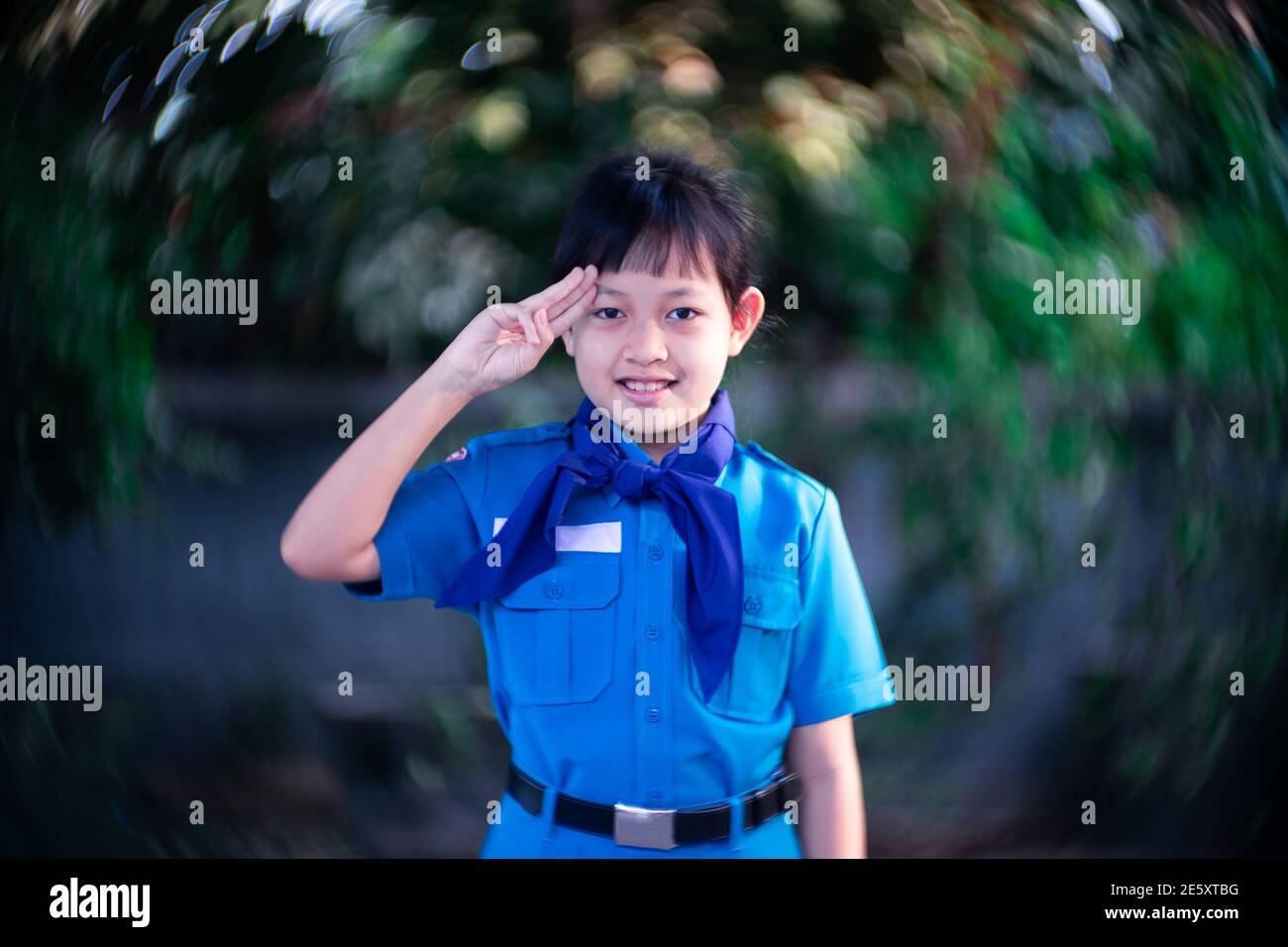 Asian uniform scout girl raise three fingers to respect with beautiful ...