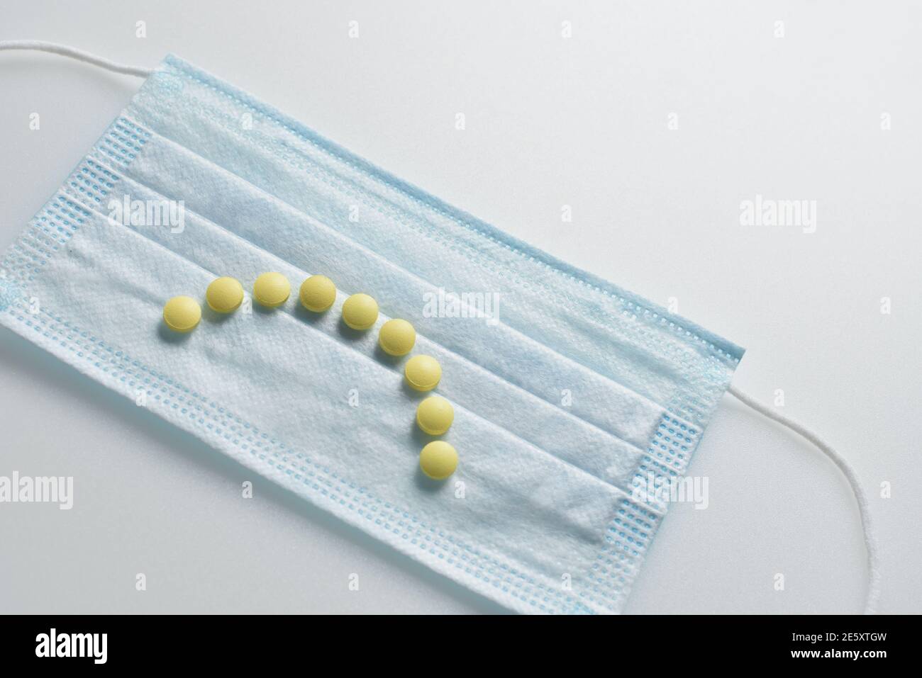Pills on face mask with sad emotion Stock Photo - Alamy