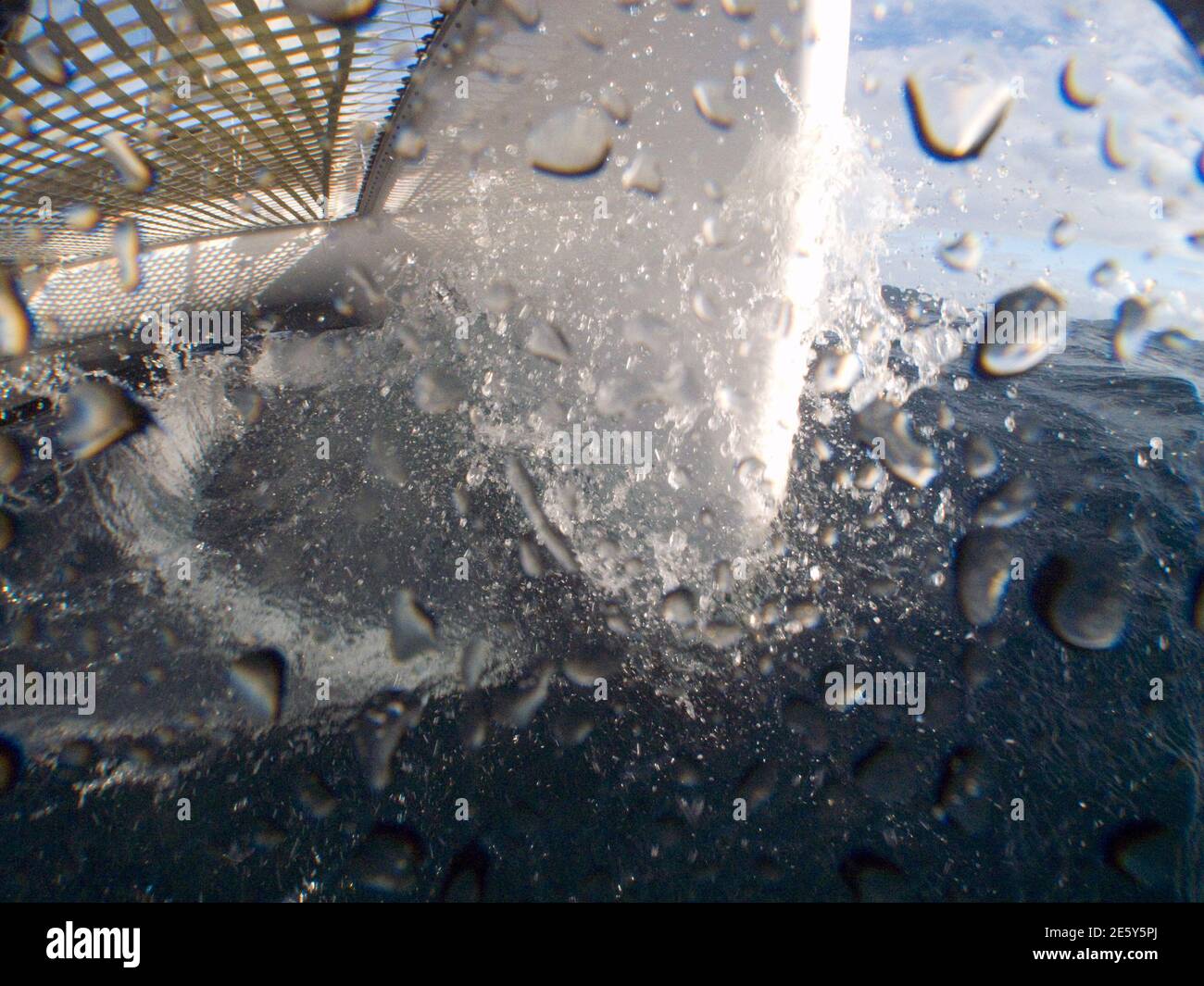 View from below of the hull of a sailing boat cutting through the water ...