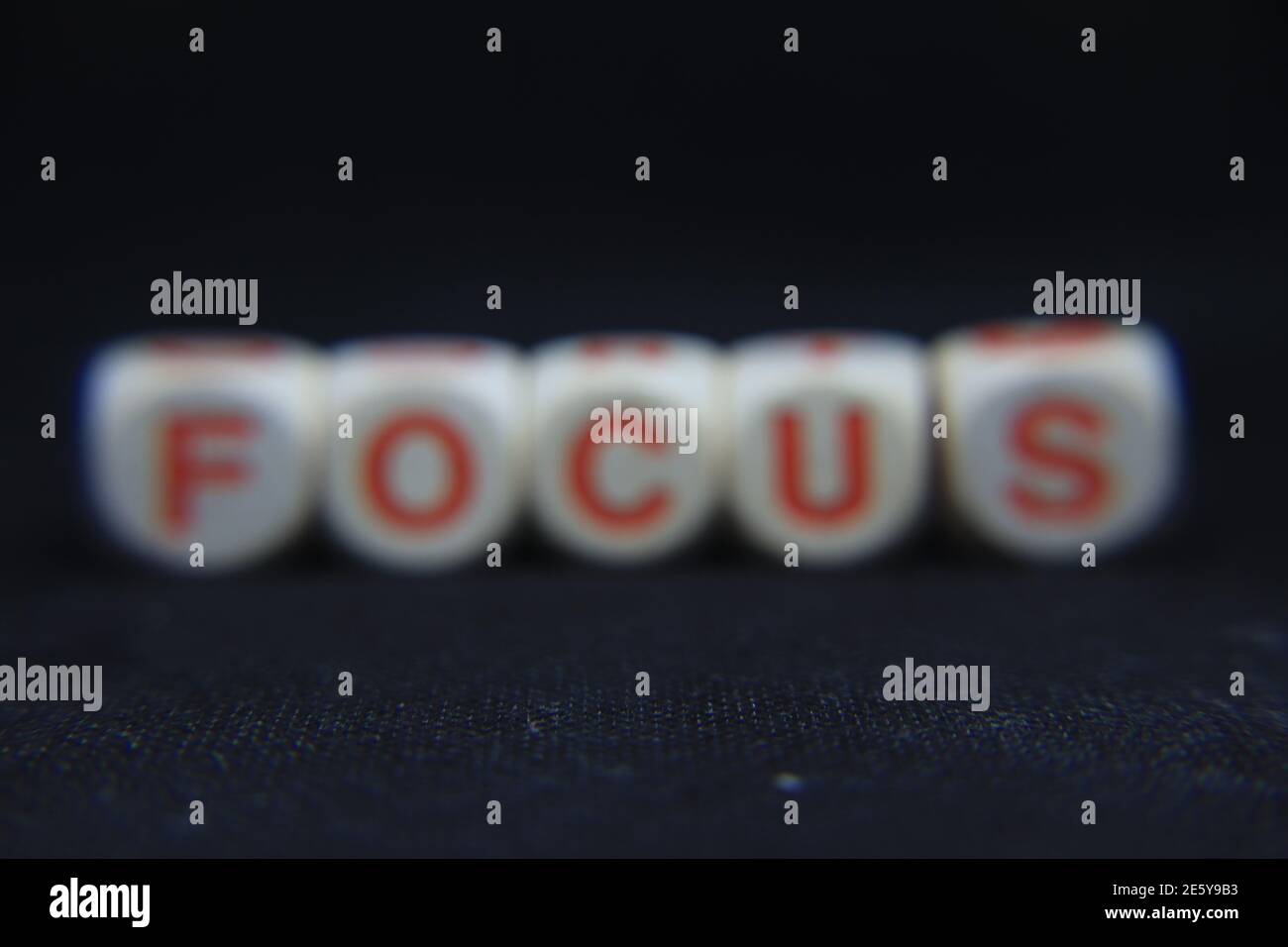 Wooden orange and white letters dice forming the writing "FOCUS" on a ...
