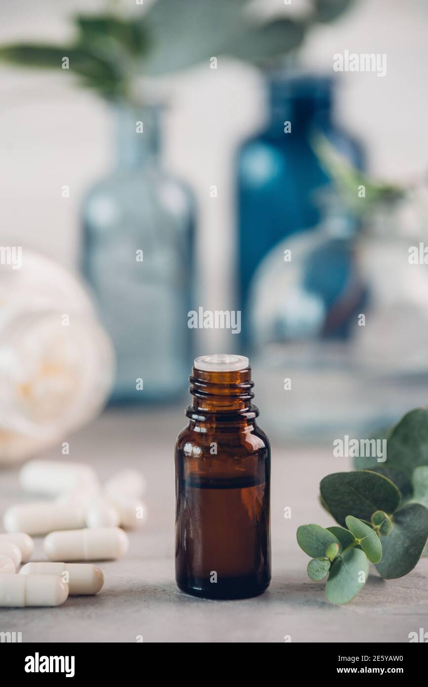 Eucalyptus essential oil and fresh leaves, white capsules pills on the ...