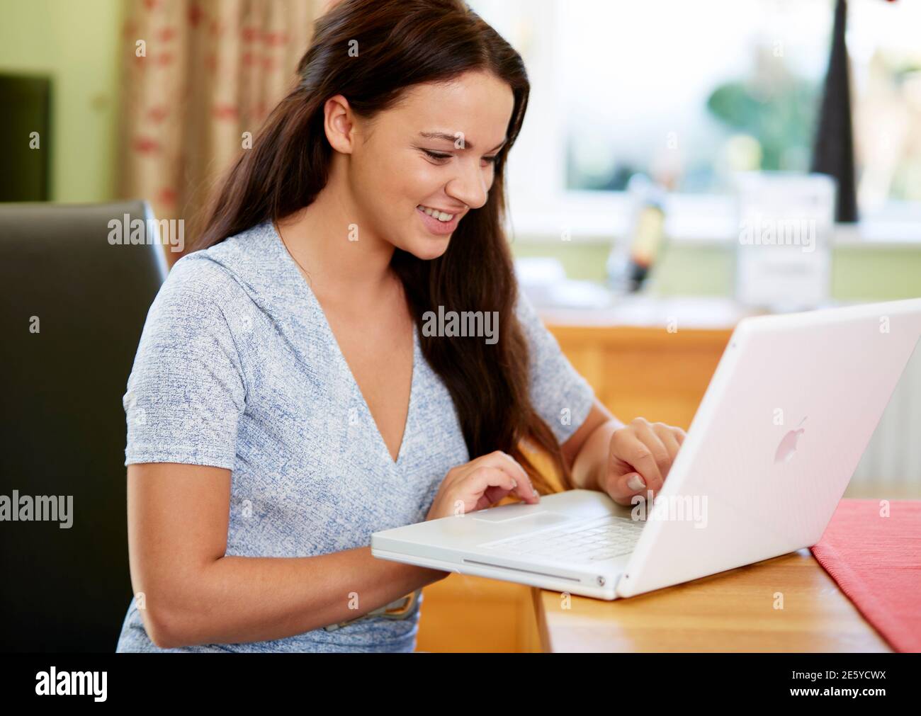 Woman smiling using laptop Stock Photo - Alamy