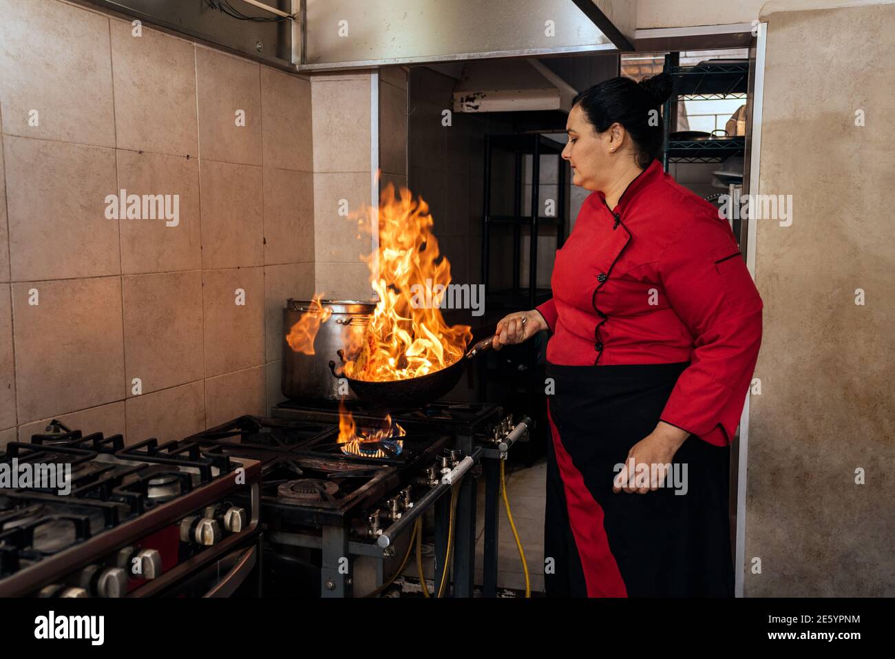Stock photo of concentrated professional chef using gas stove in ...