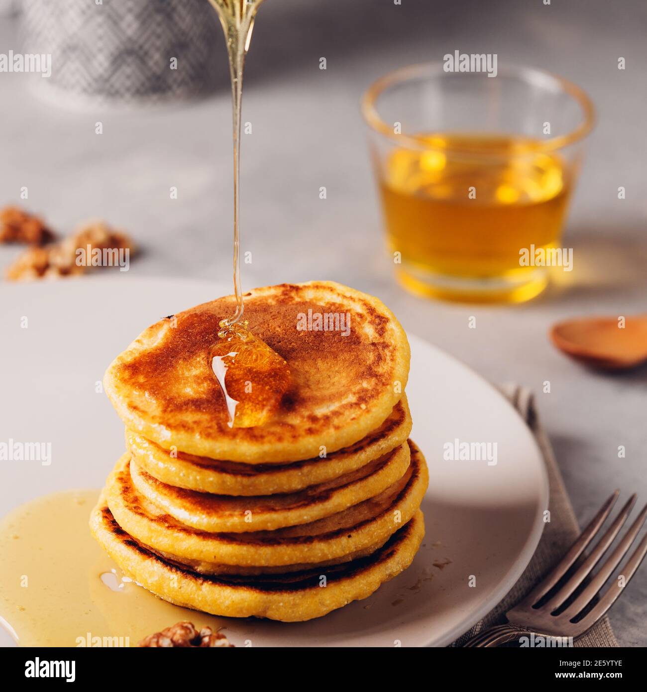 Yellow pancakes with corn flour and turmeric, dressed honey and red ...