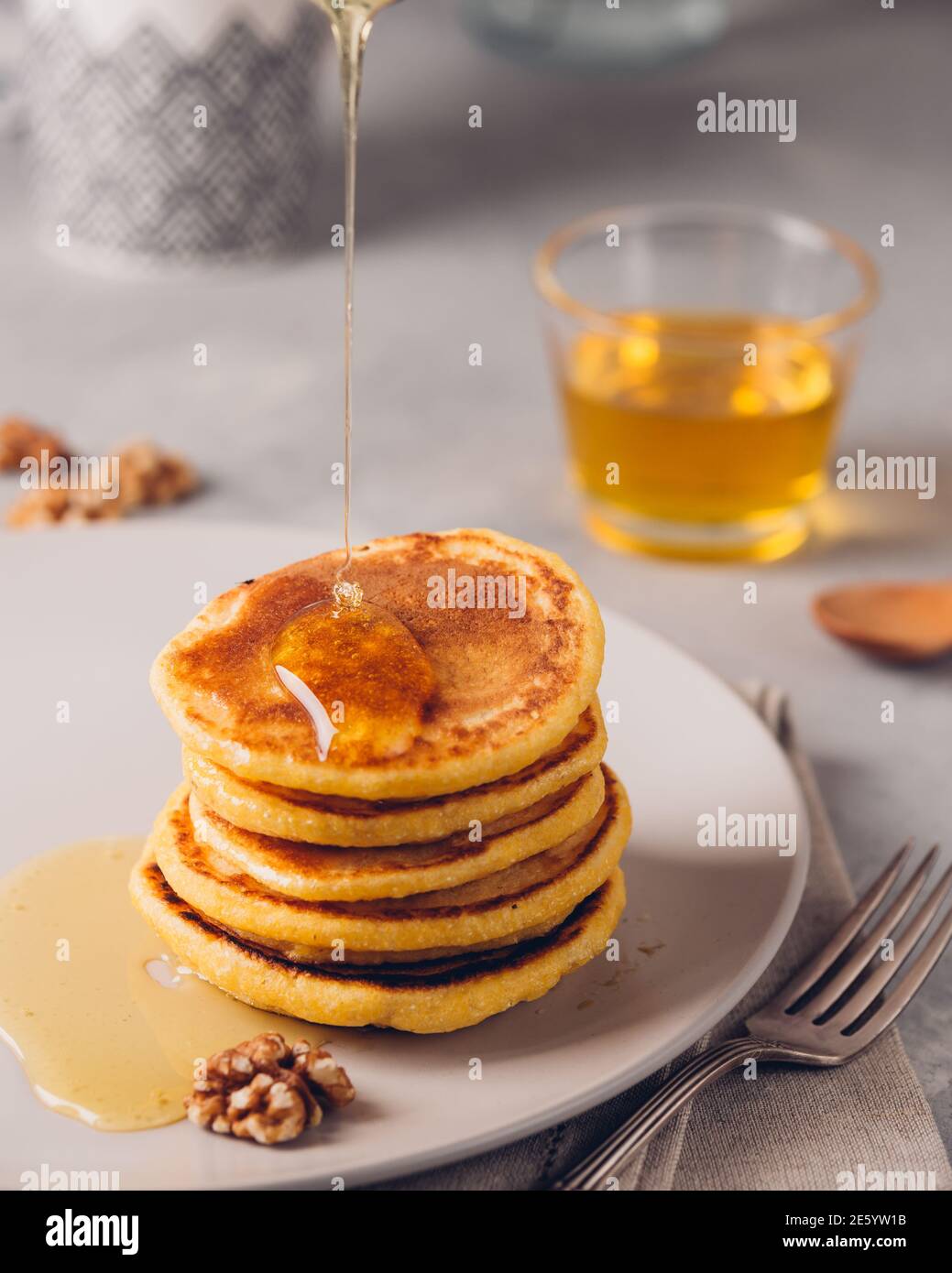 Yellow pancakes with corn flour and turmeric, dressed honey and red ...