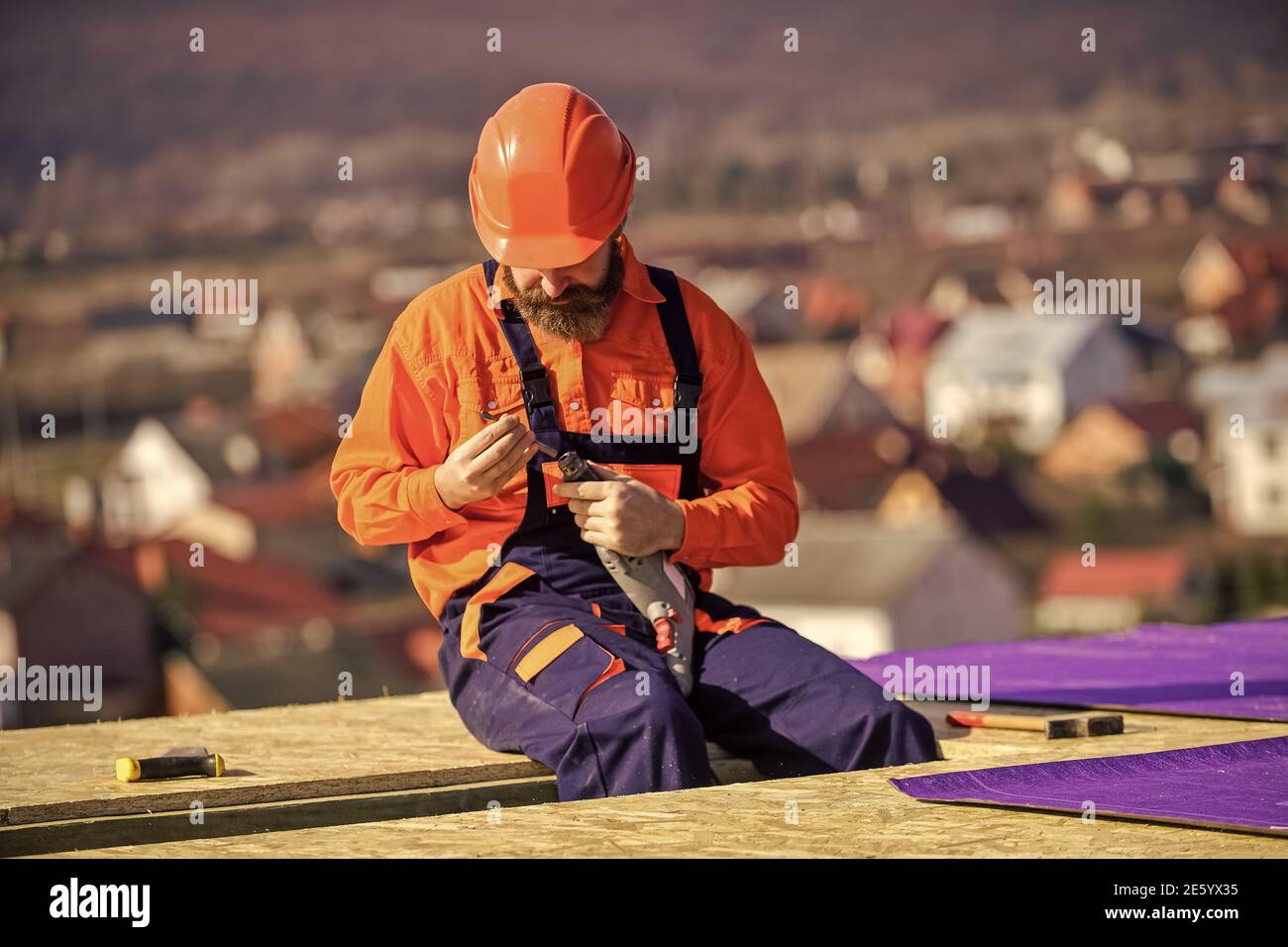 Flat roof installation. Man hard hat working outdoor landscape ...