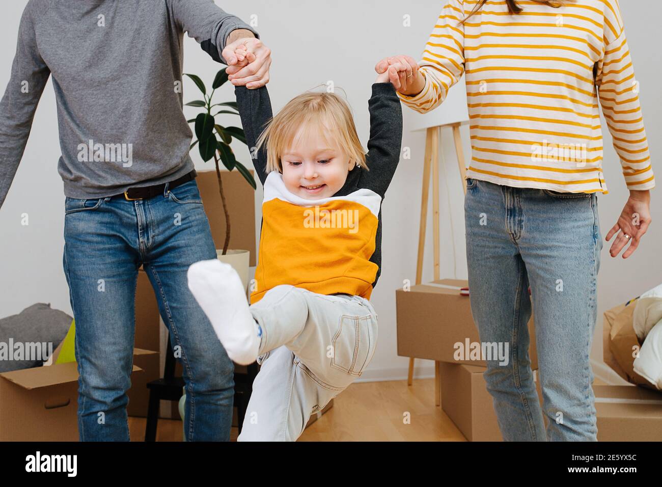 Parents lift up the child, holding hands Stock Photo - Alamy