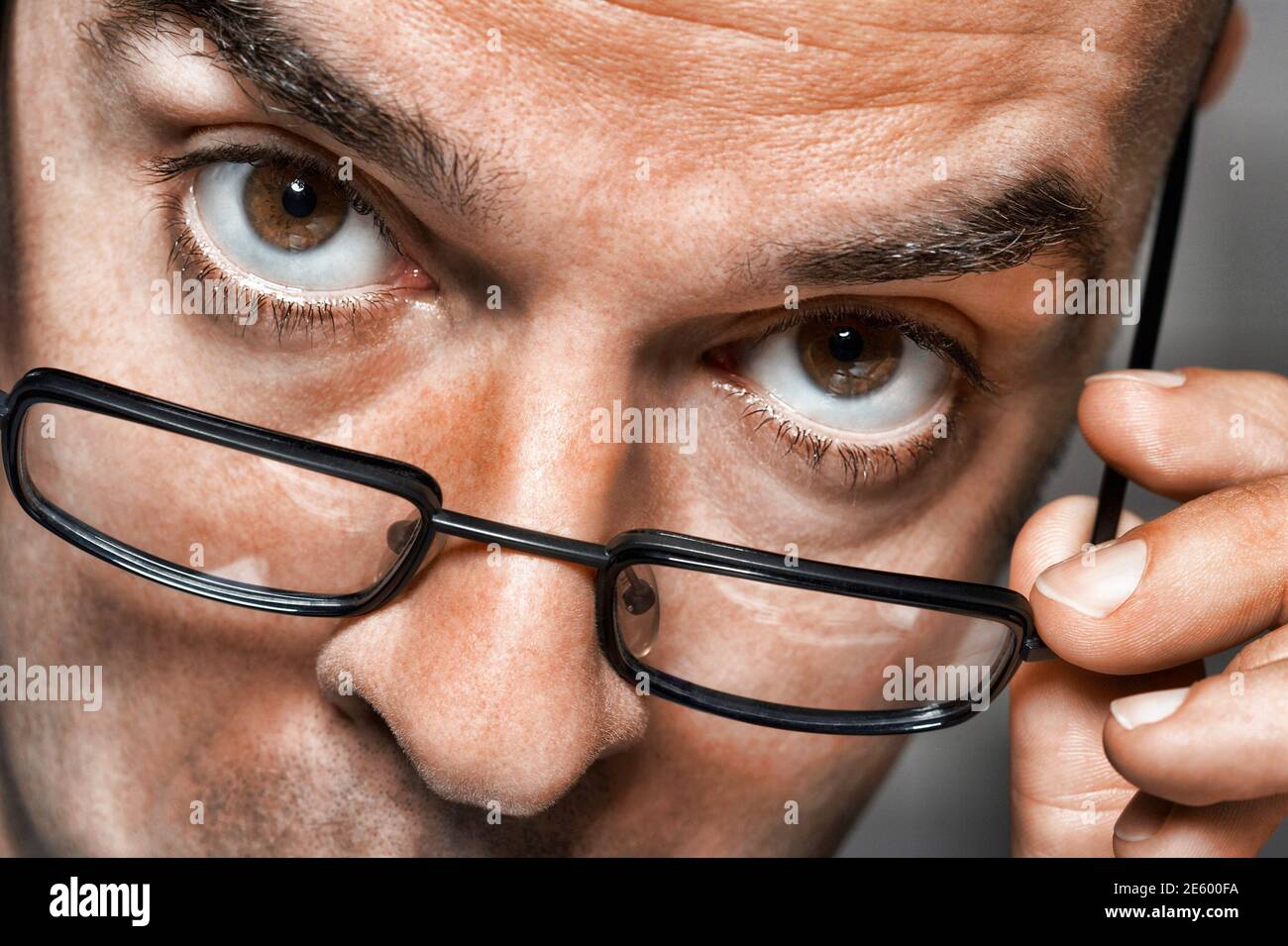 Portrait of a businessman with hand on glasses making a face Stock ...