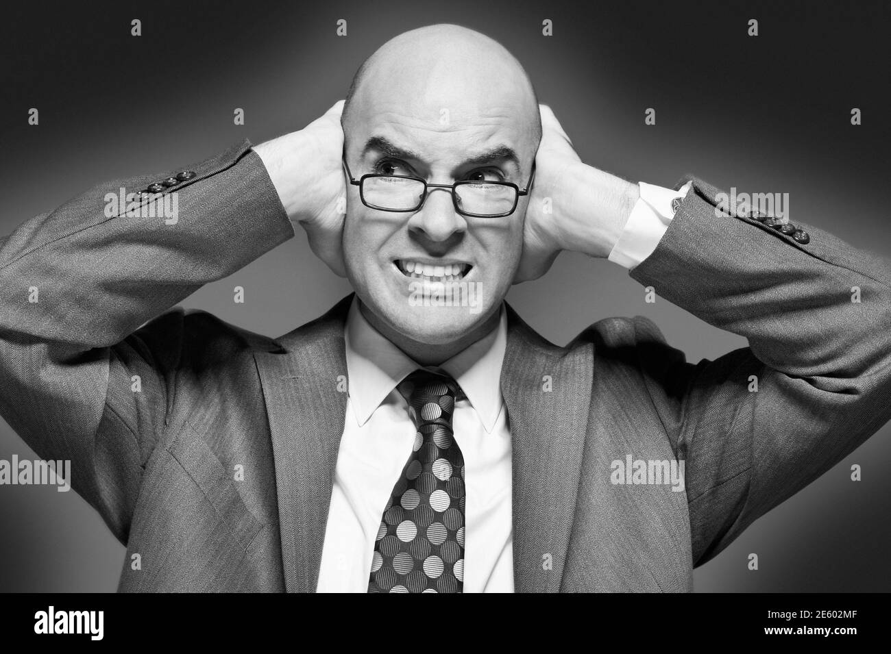 Black and white photo of businessman with hands over ears Stock Photo ...
