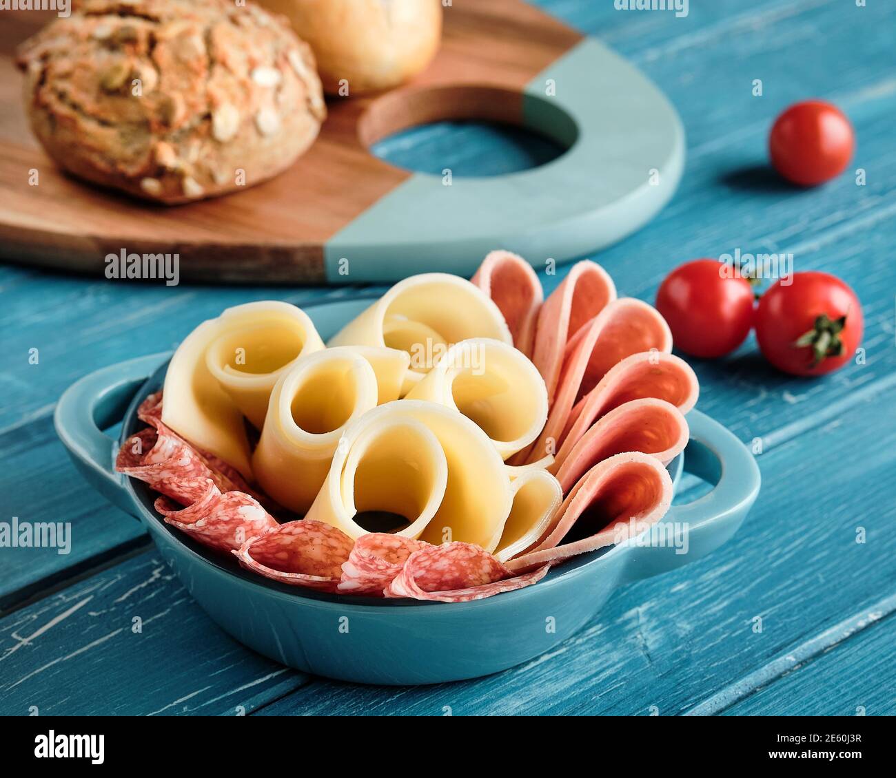 Italian salami, sausage and cheese in ceramic bowl. Cherry tomatoes ...