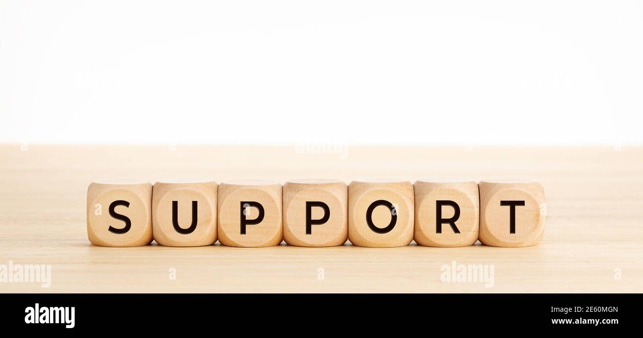 Support word on wooden blocks on wood table. Copy space. White ...