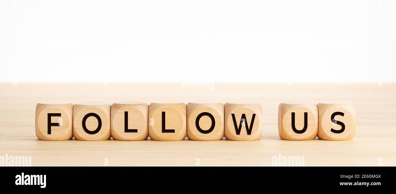 Follow us word on wooden blocks on wood table. Copy space. White ...
