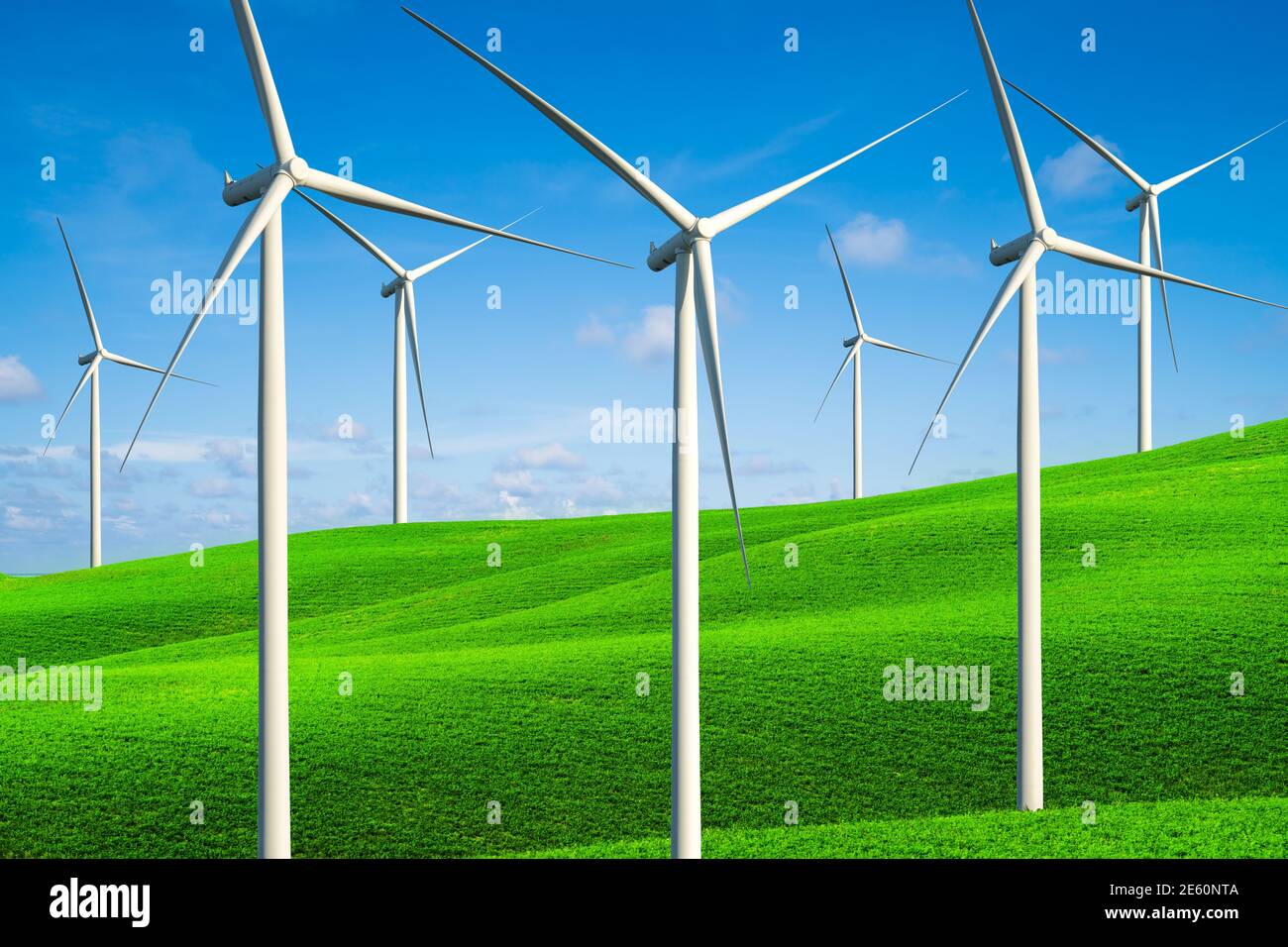 Wind turbines farm on a green grass rolling hills against blue sky and ...