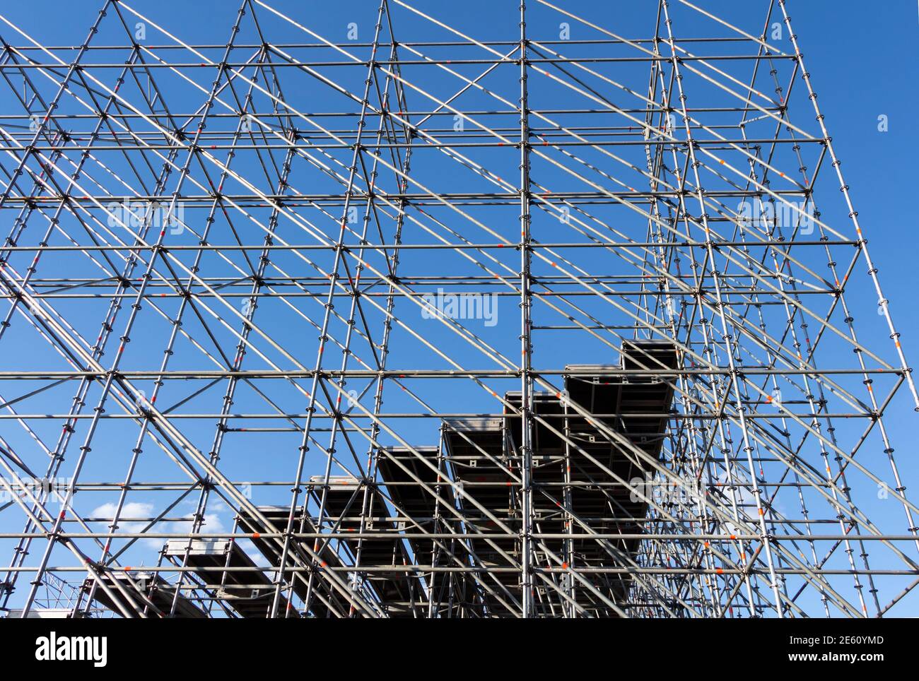 Scaffolding for the spectator stands on a white background of blue sky ...