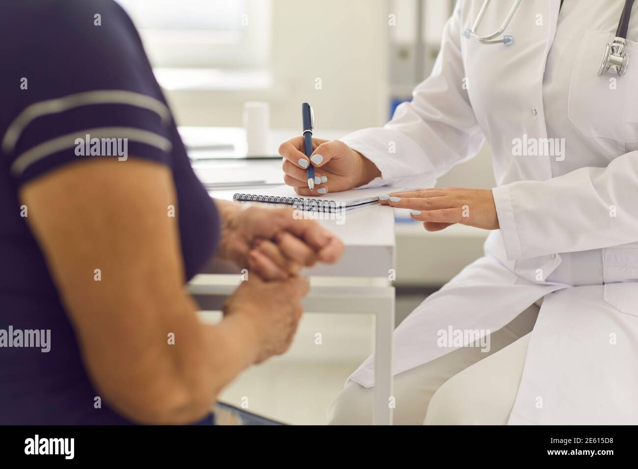 Hands of a female doctor writing notes to patient about a medical ...