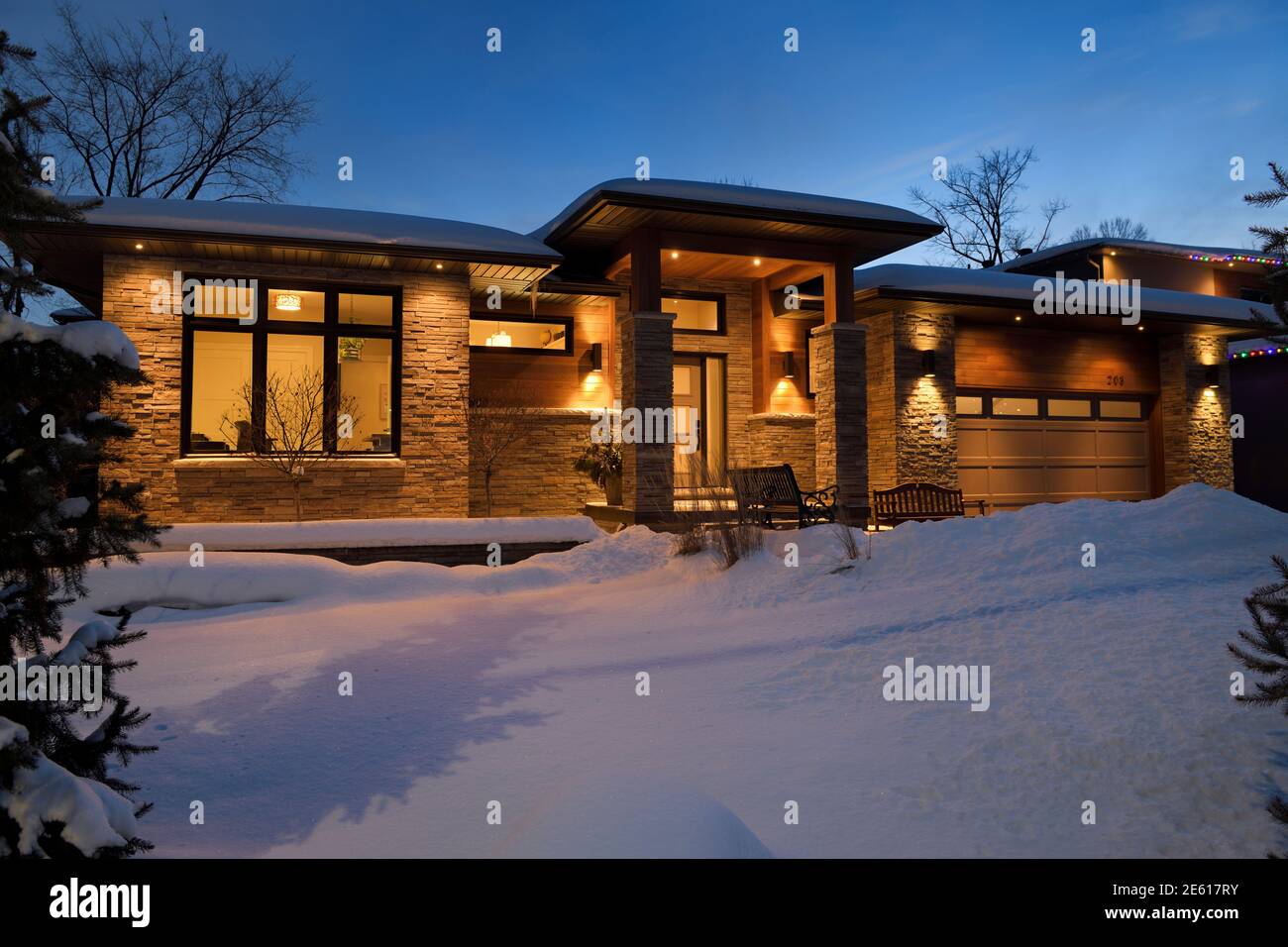 Snow covered front yard of modern house in Ontario Canada at twilight ...