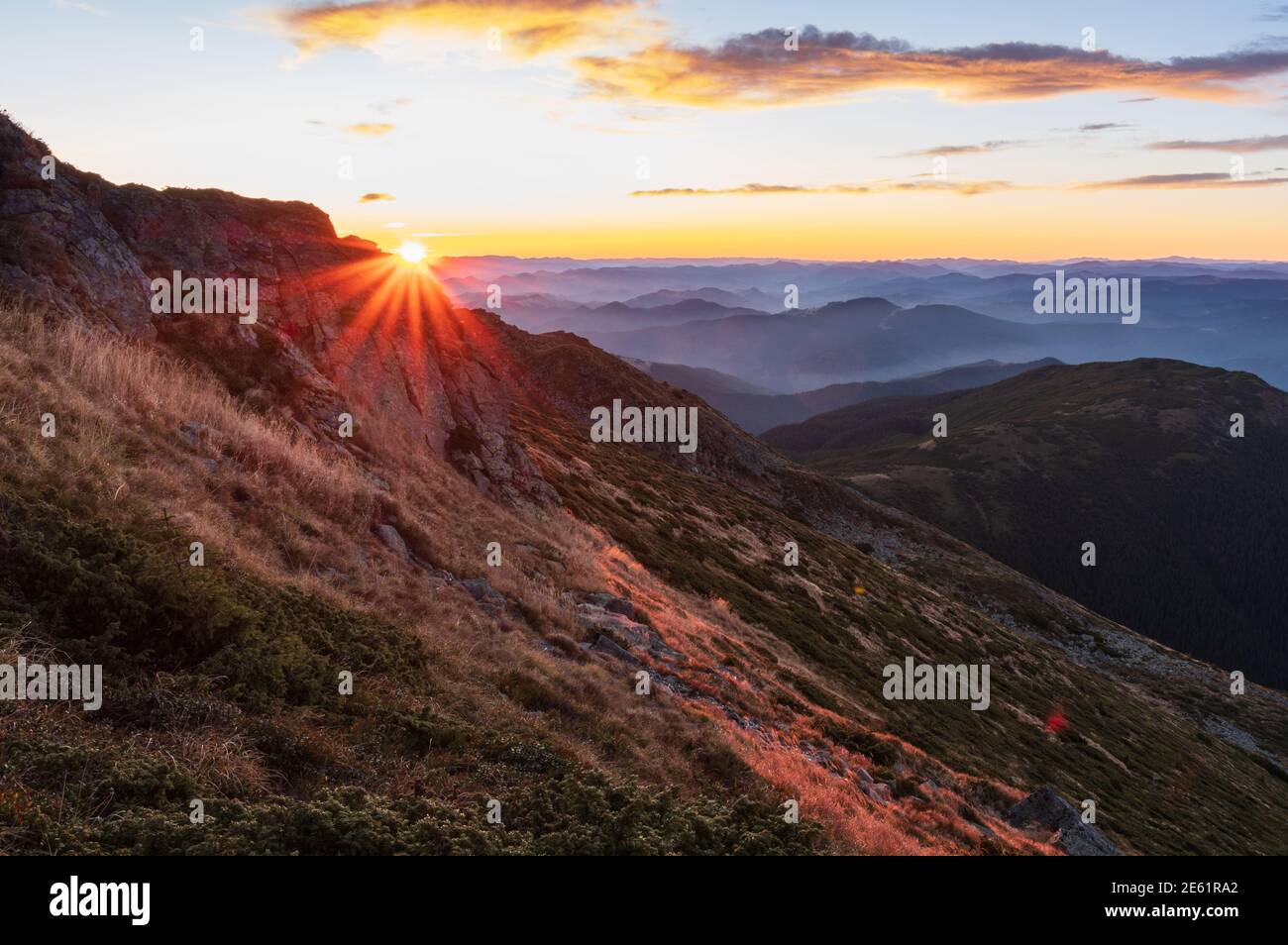 The sun coming out of the mountains. Bright rays of the sun. Lots of ...