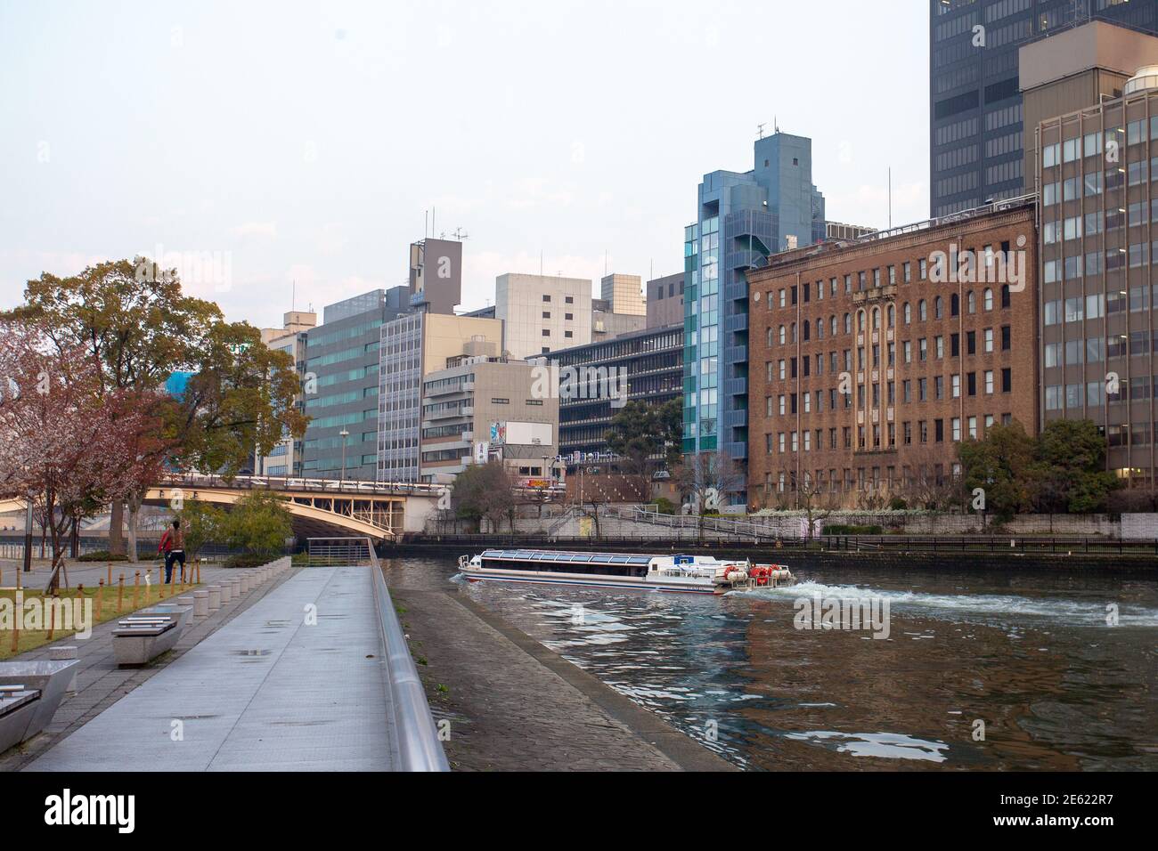 Pleasure boat (touristic) on river O in Osaka. Reflection of buildings ...