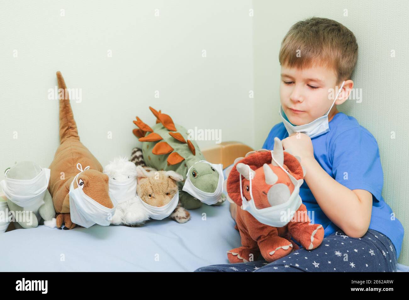Child plays role-playing games. Baby bay and his dinosaurs toys wearing ...