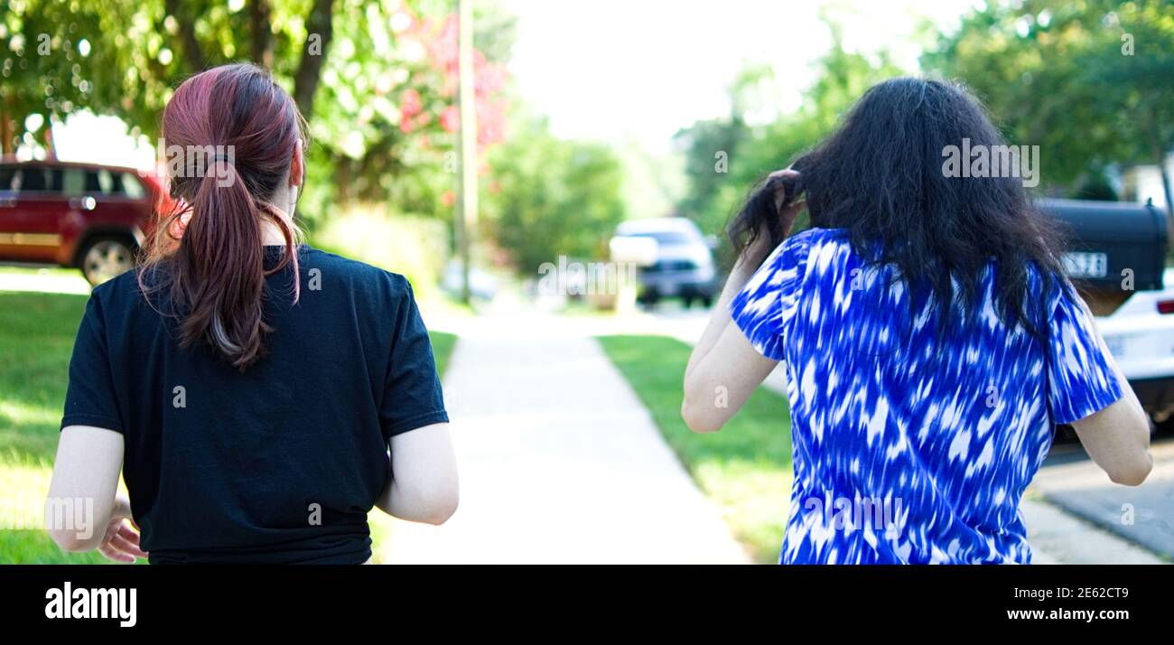 Two teenage friends walk outside in the neighborhood Stock Photo - Alamy