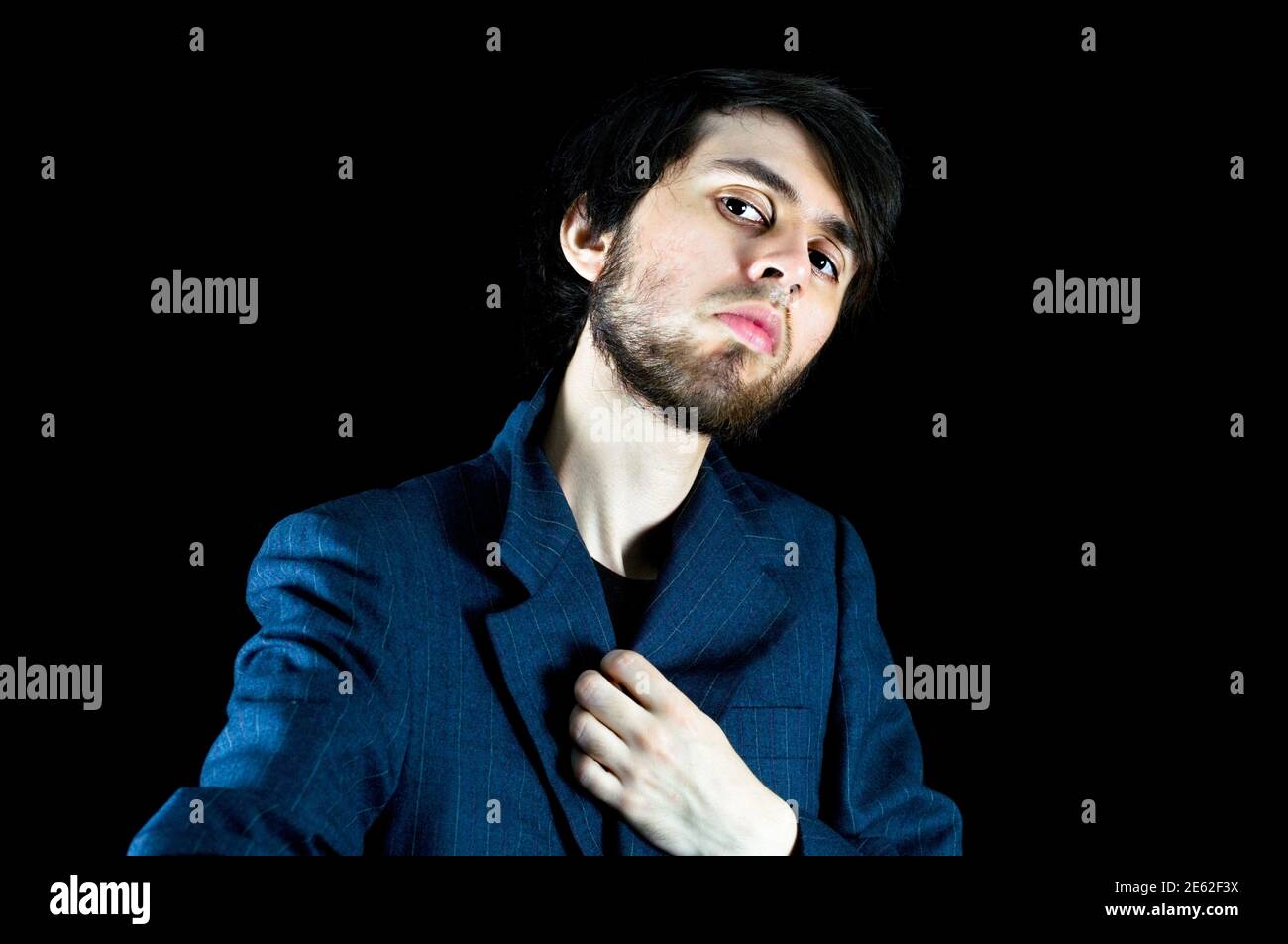 Young man giving a look to the camera while his left hand is on the ...